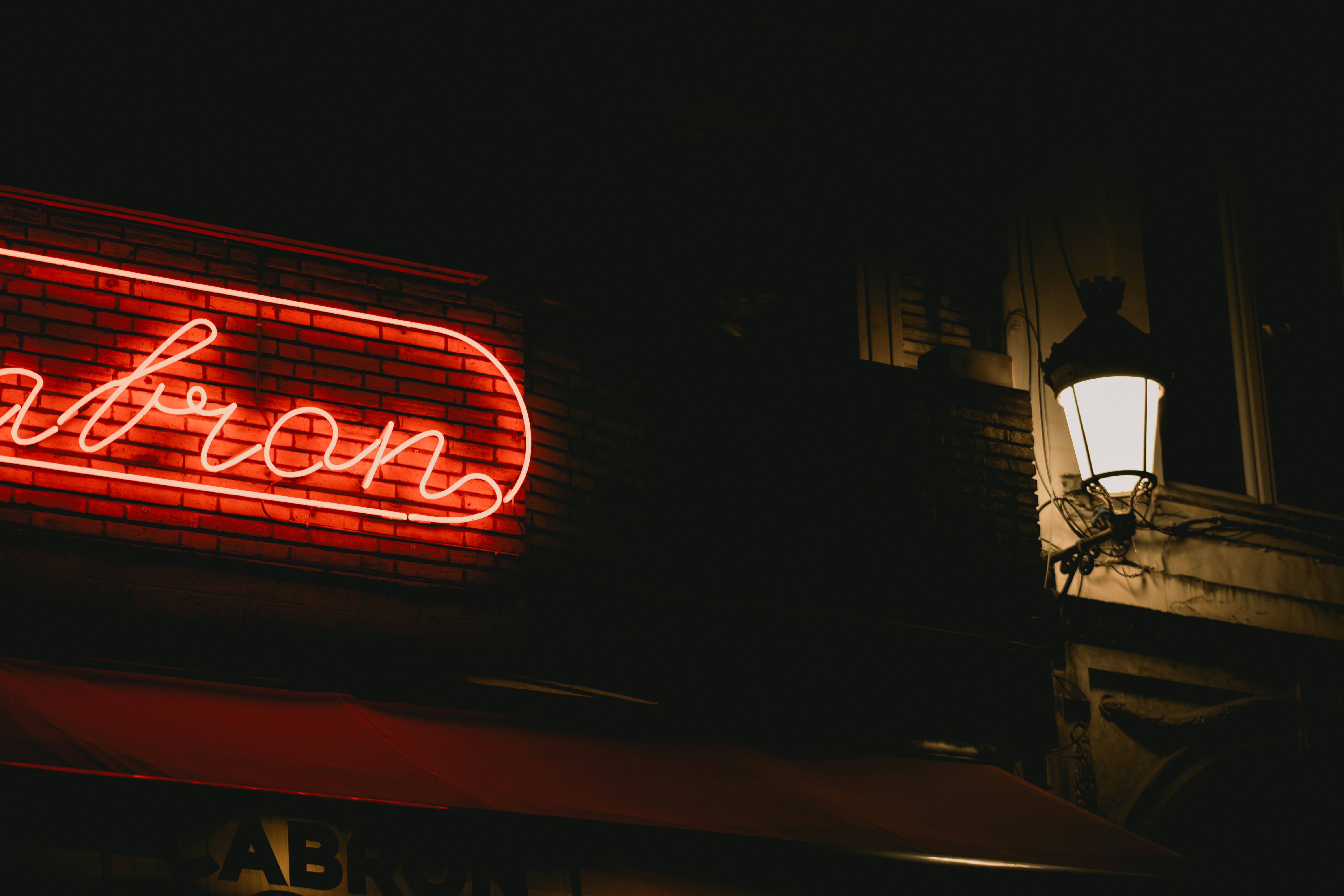 Neon Sign and Street Lamp in Night Facade