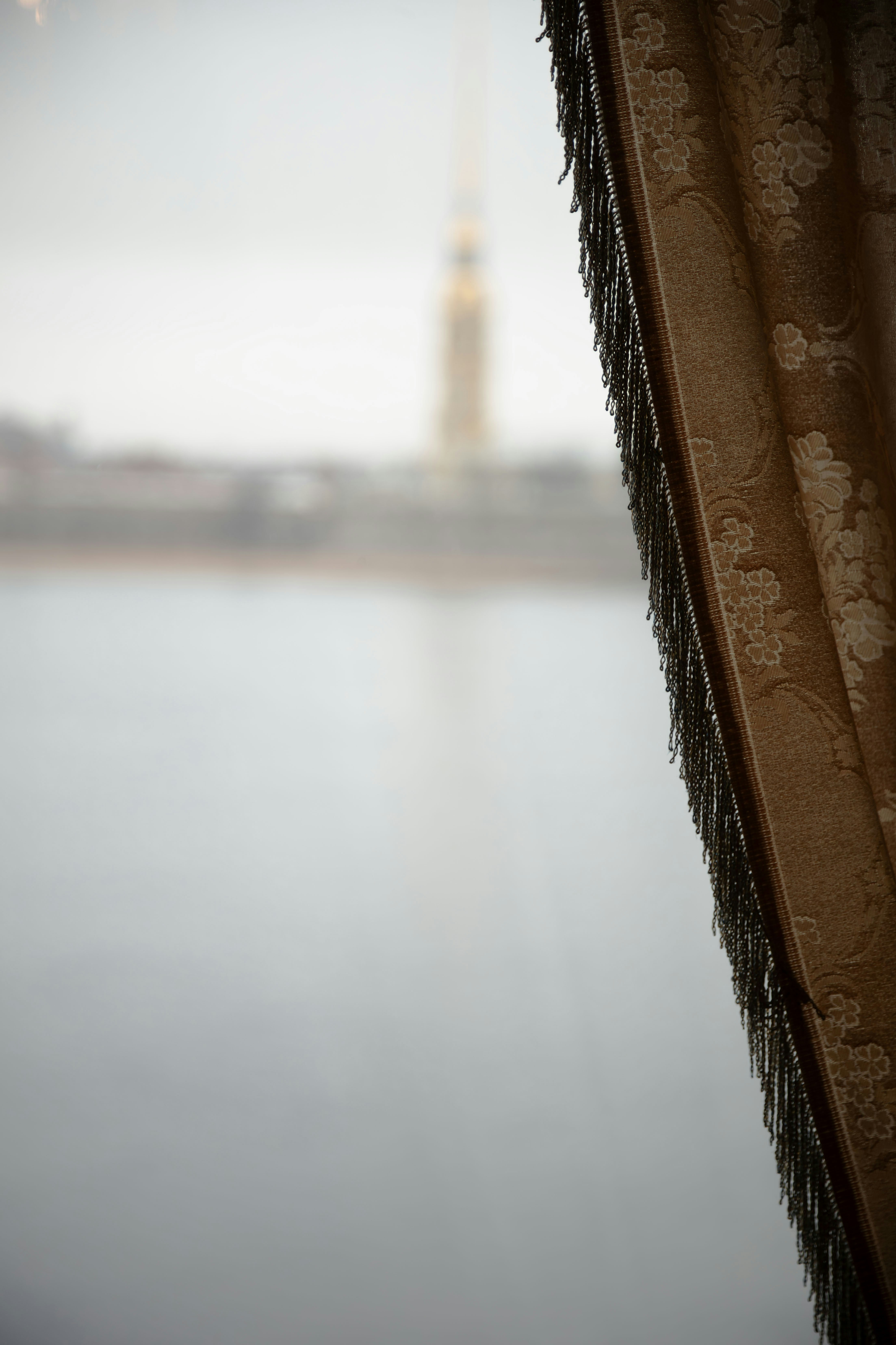 Curtains at the Window: A Glimpse of the City Through Fringed Drapery