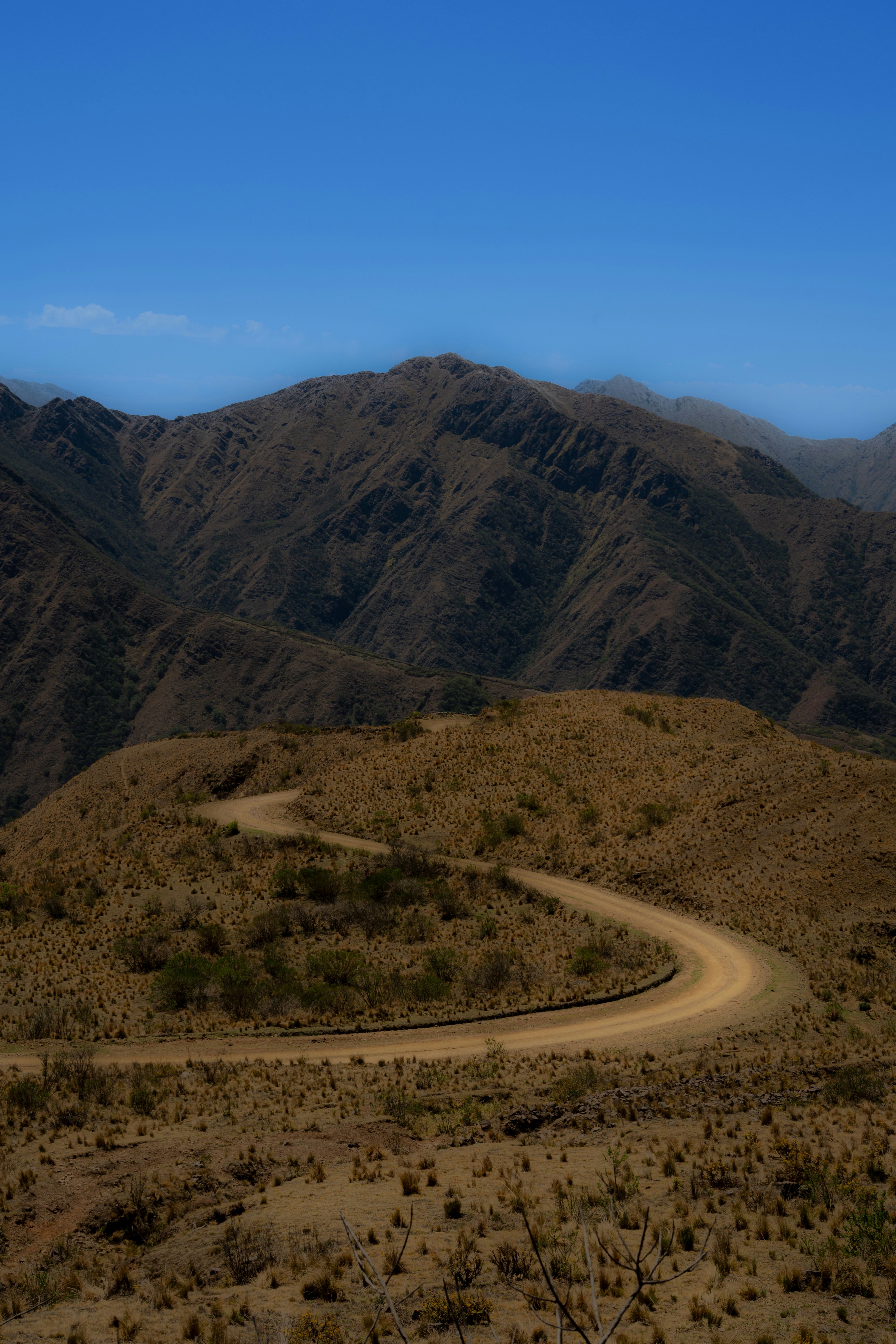 Curving dirt road cutting through steep mountain slopes on the way to Santa Ana, showing the wild and untouched beauty of Jujuy.