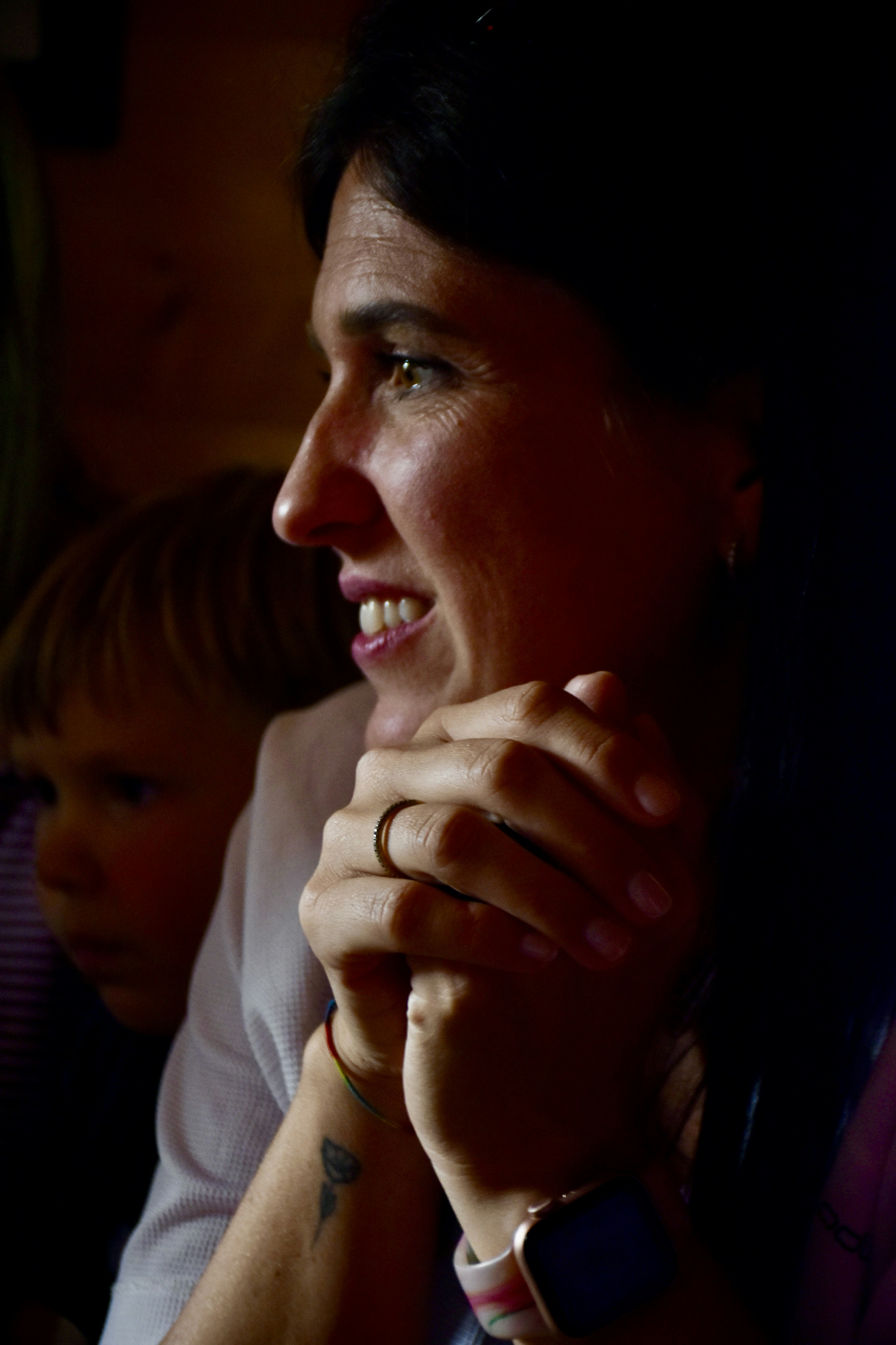 Close-up of a joyful conversation: hands clasped beneath a warm smile