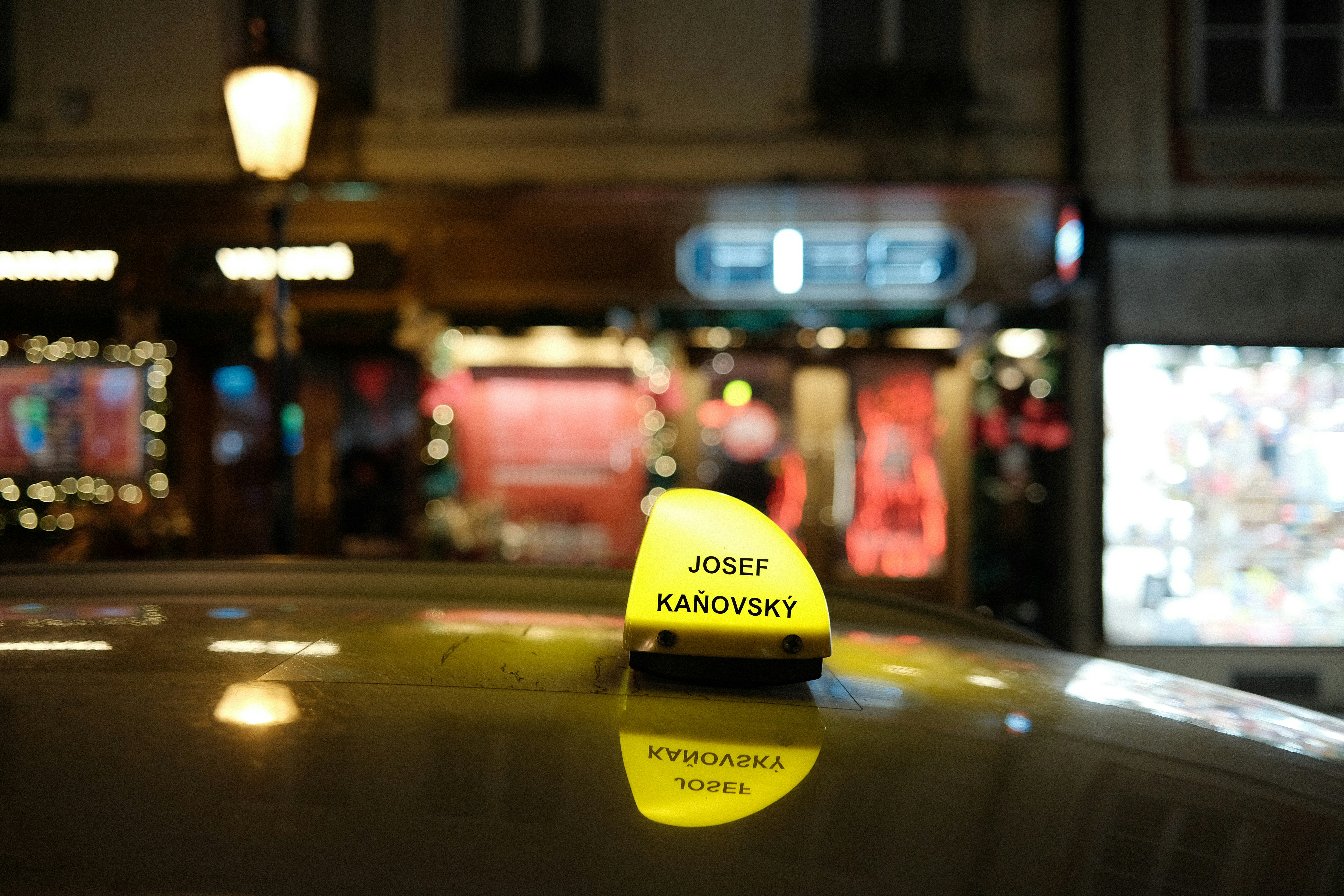 Yellow taxi sign glows above a blurred city street