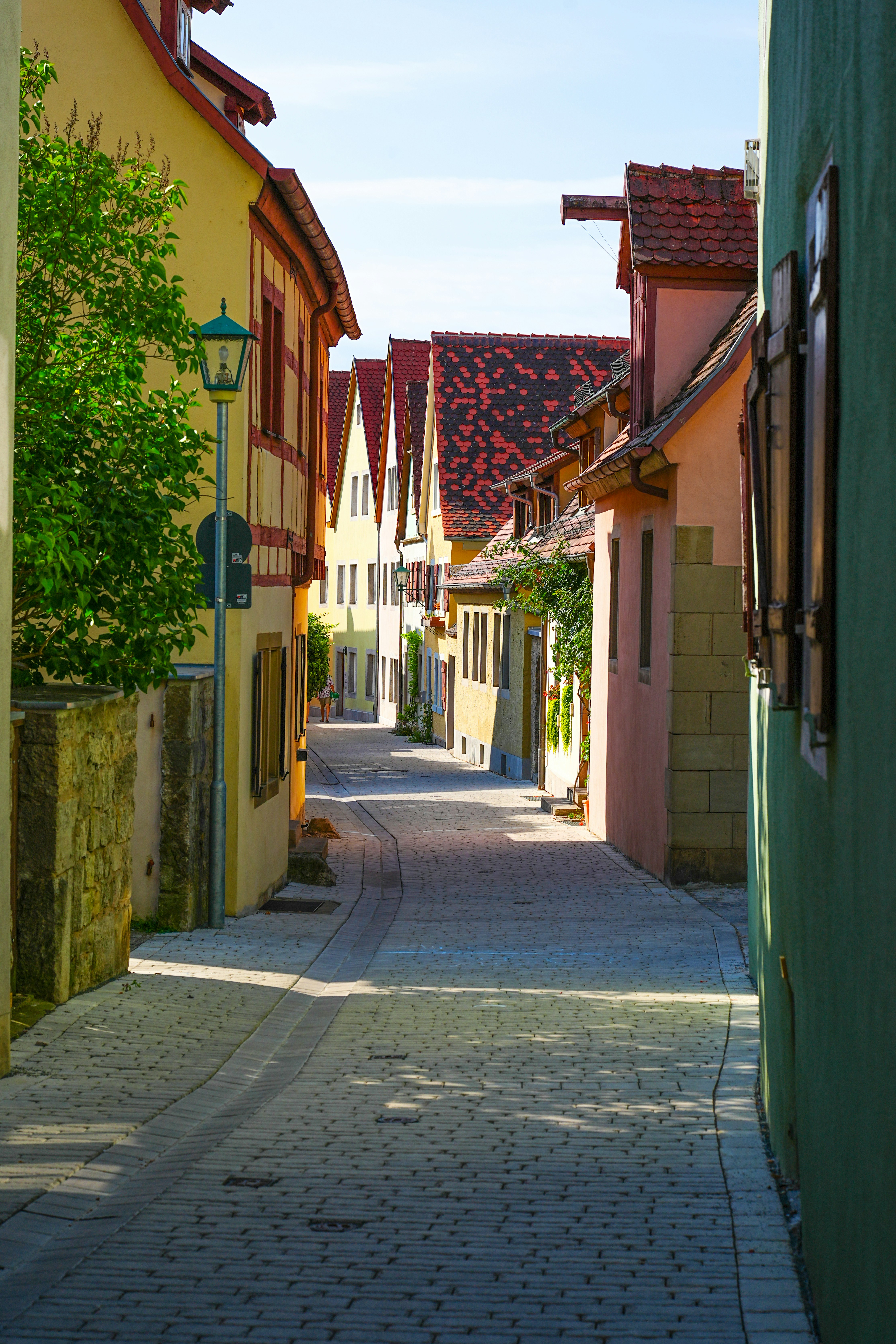 Sunlit Alleys: Colorful Facades Converge in a Quiet European Street