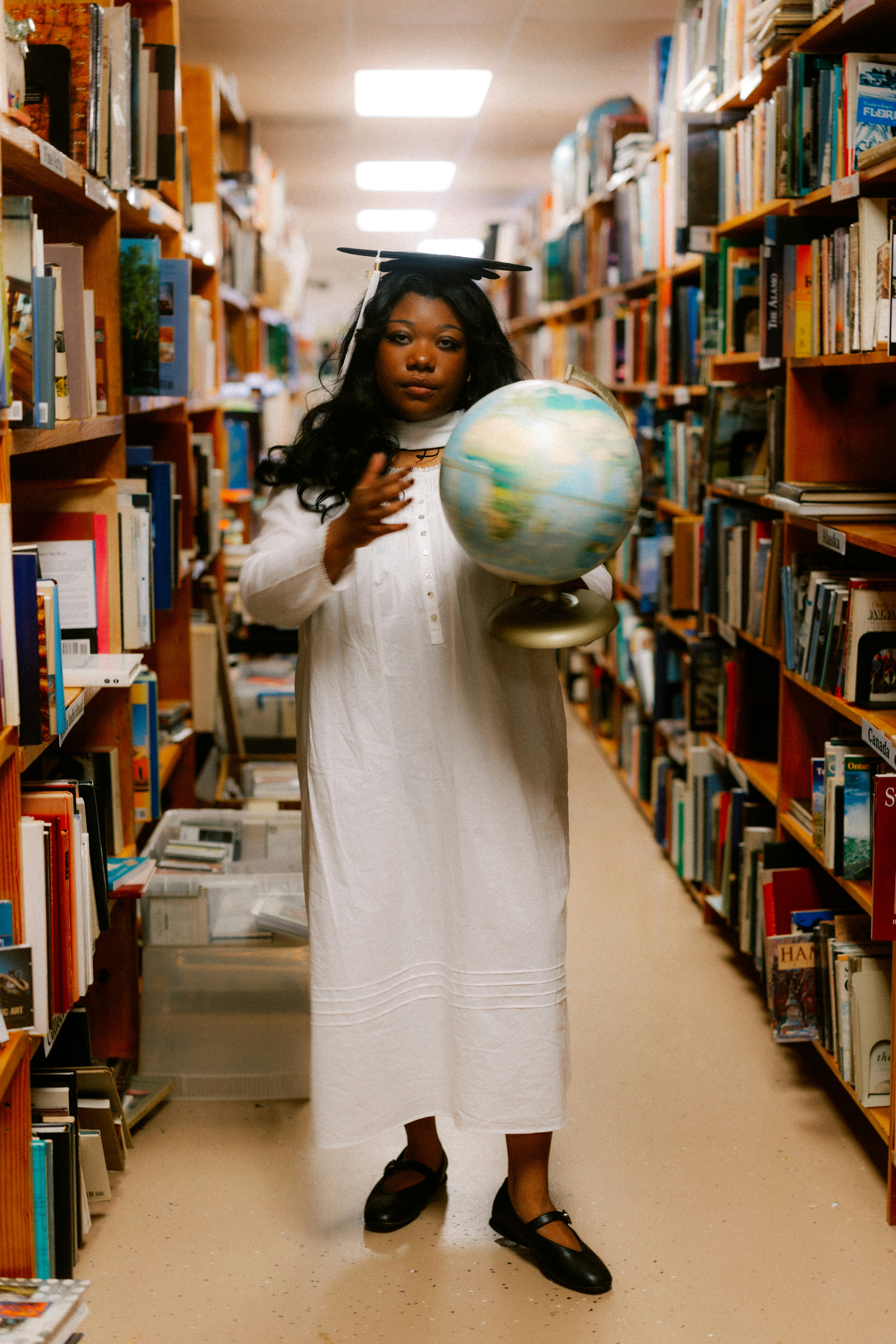Graduation in the Stacks: A Student with a Globe