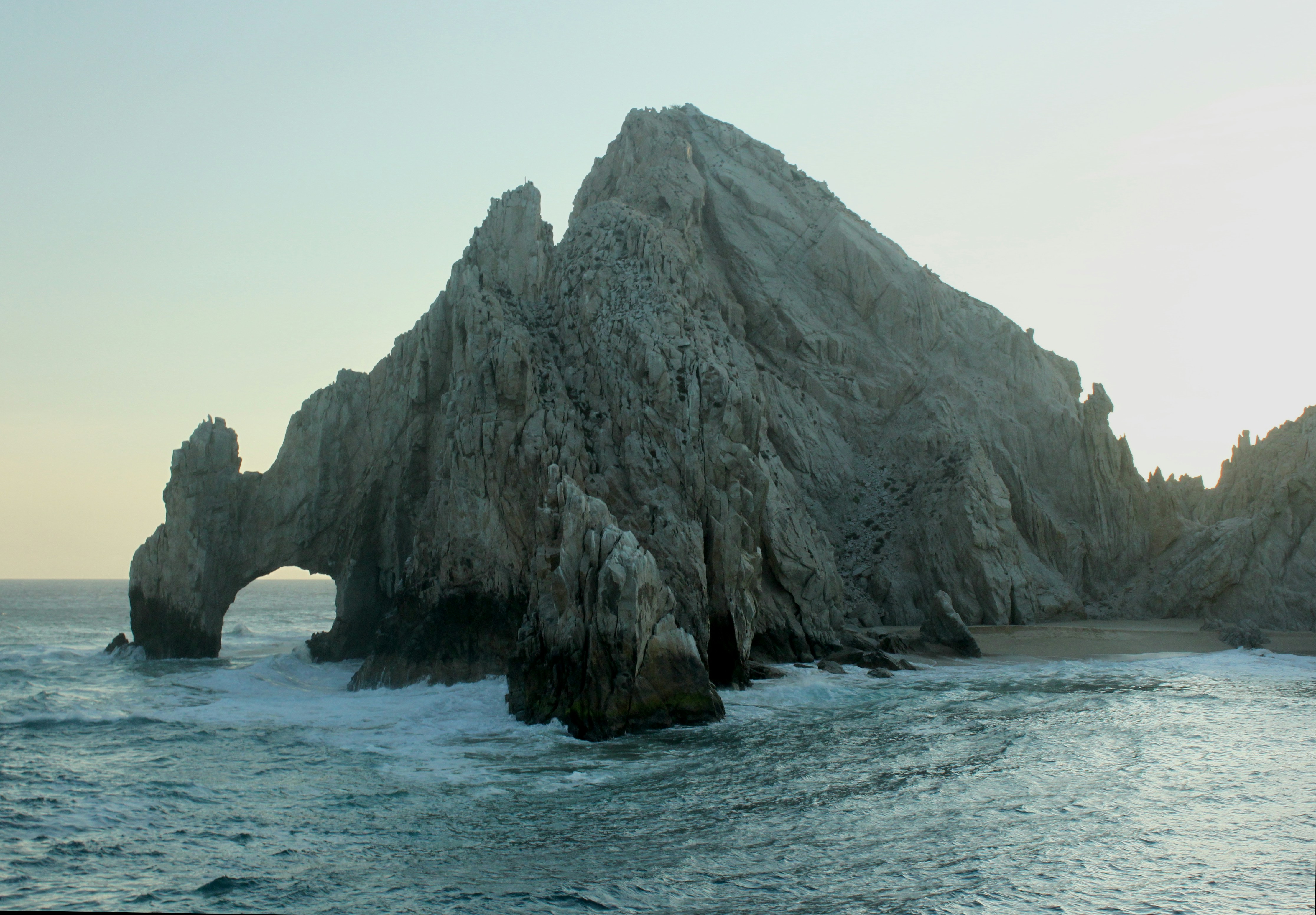 Stone Arch and Peak: Coastal Rock Formation at Dusk