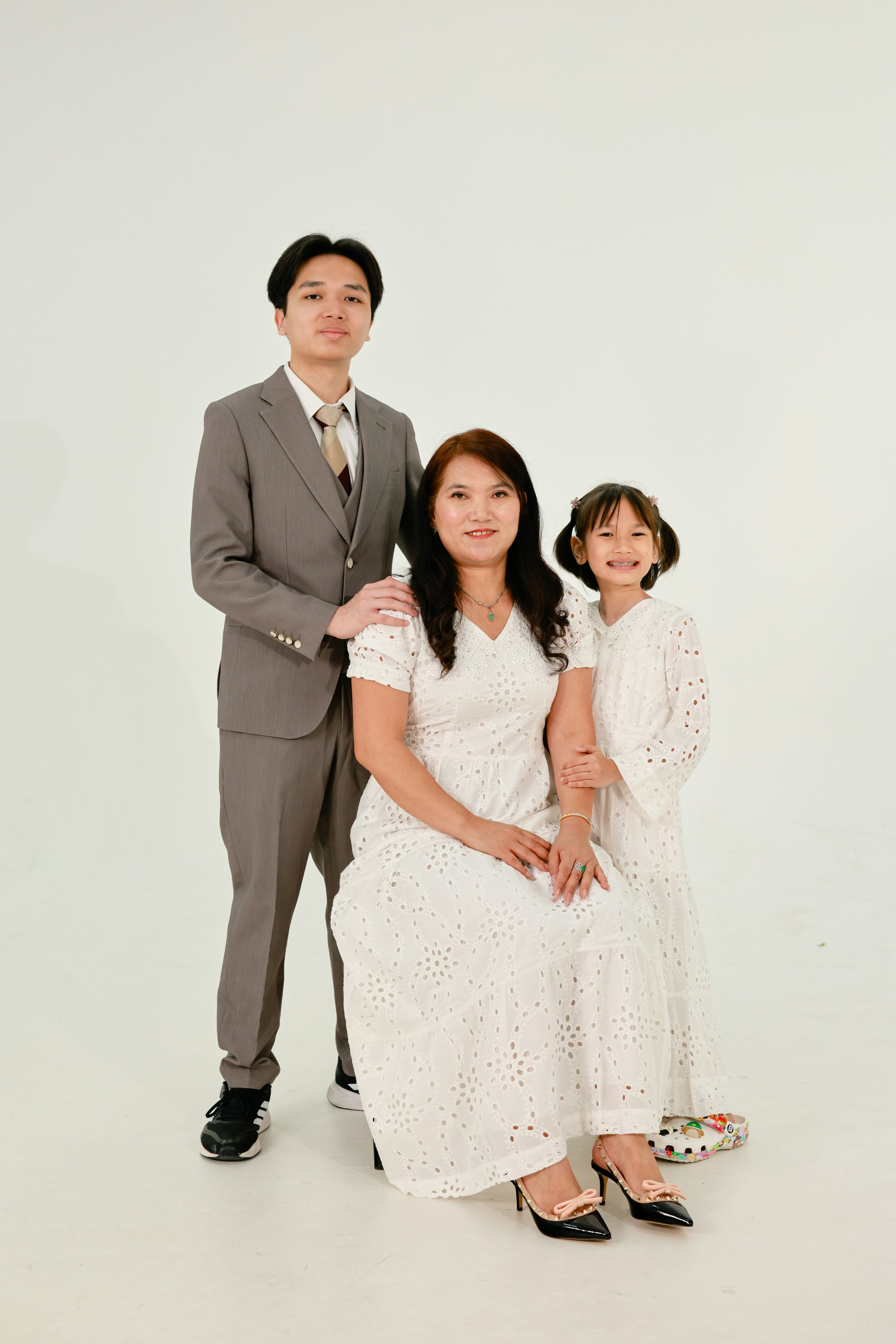 Family Portrait in White: A Formal Trio in a Studio