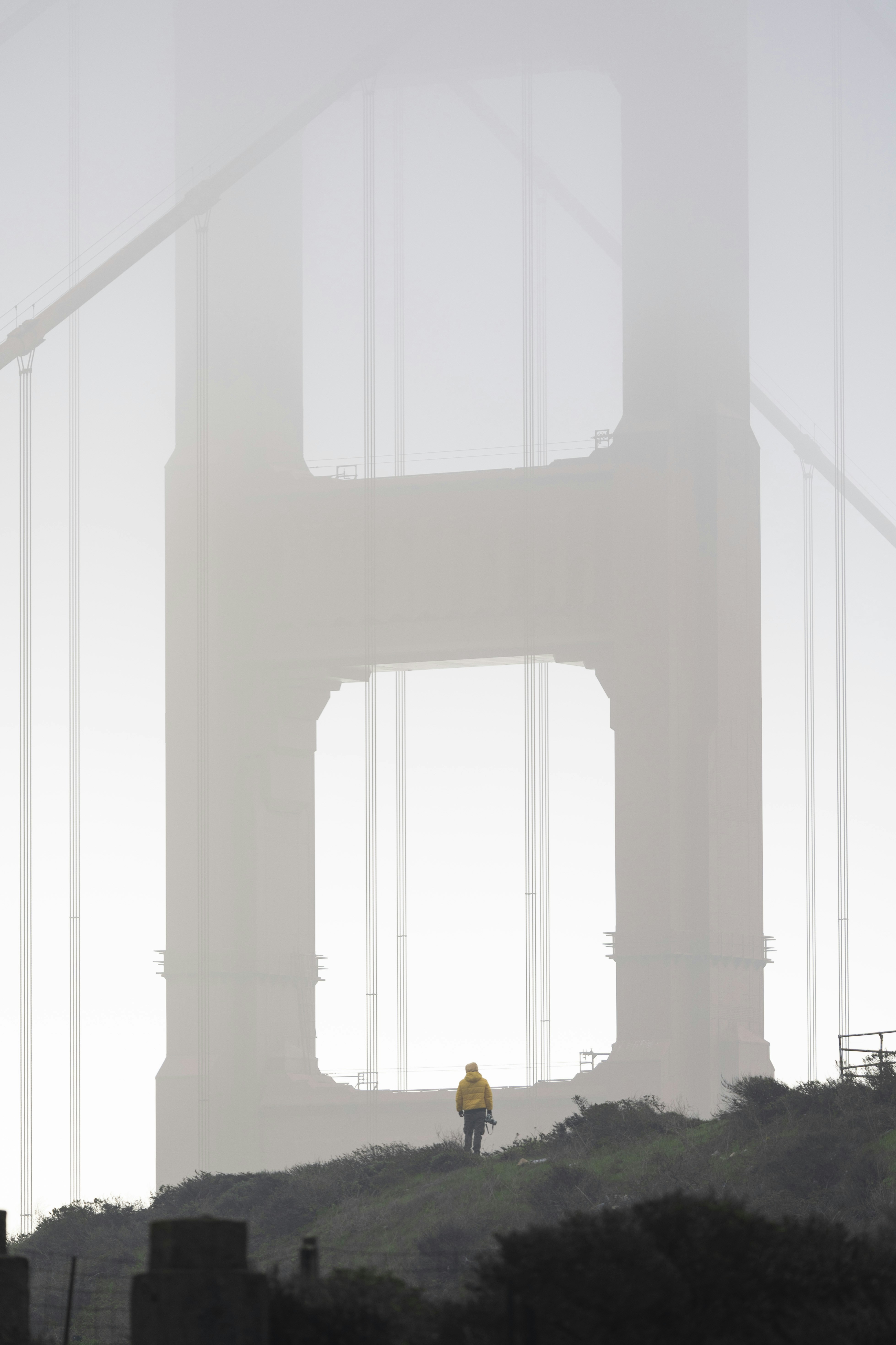  solitary figure on the misty span beneath the towers