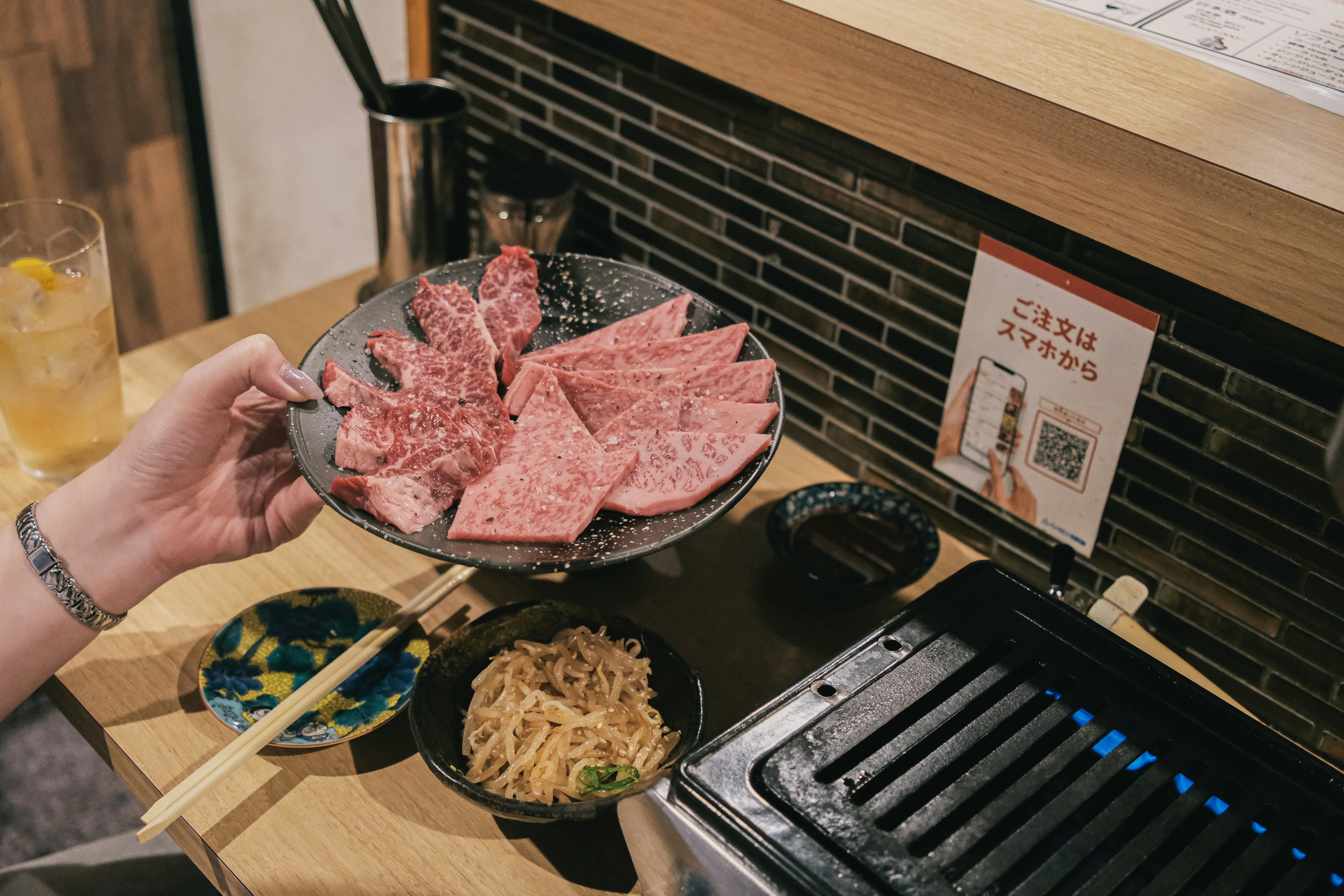 Sliced Wagyu on a sizzling grill at a cozy counter