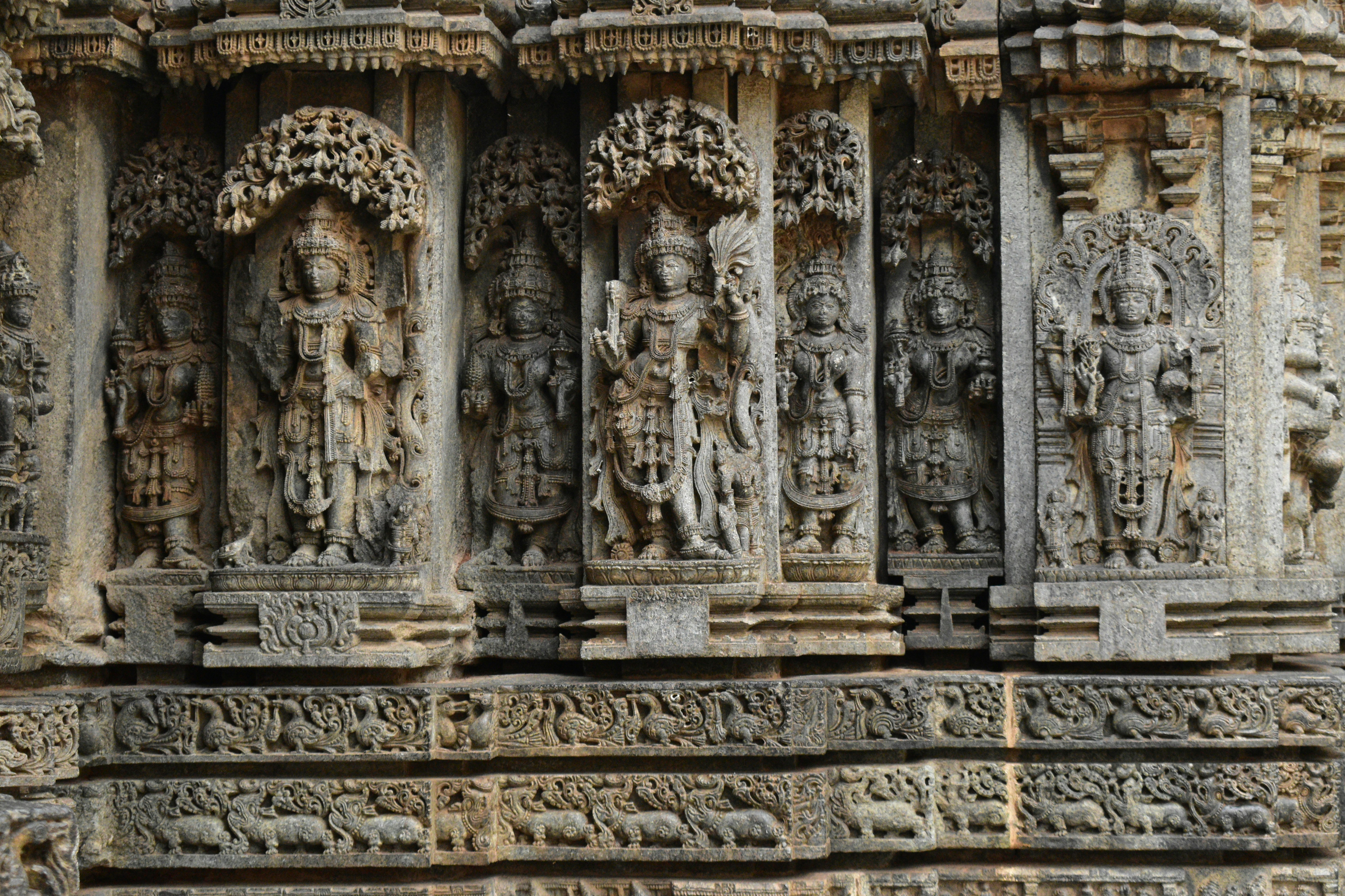 Stone Carved Frieze: Ancient Deities Framed by Repeated Reliefs