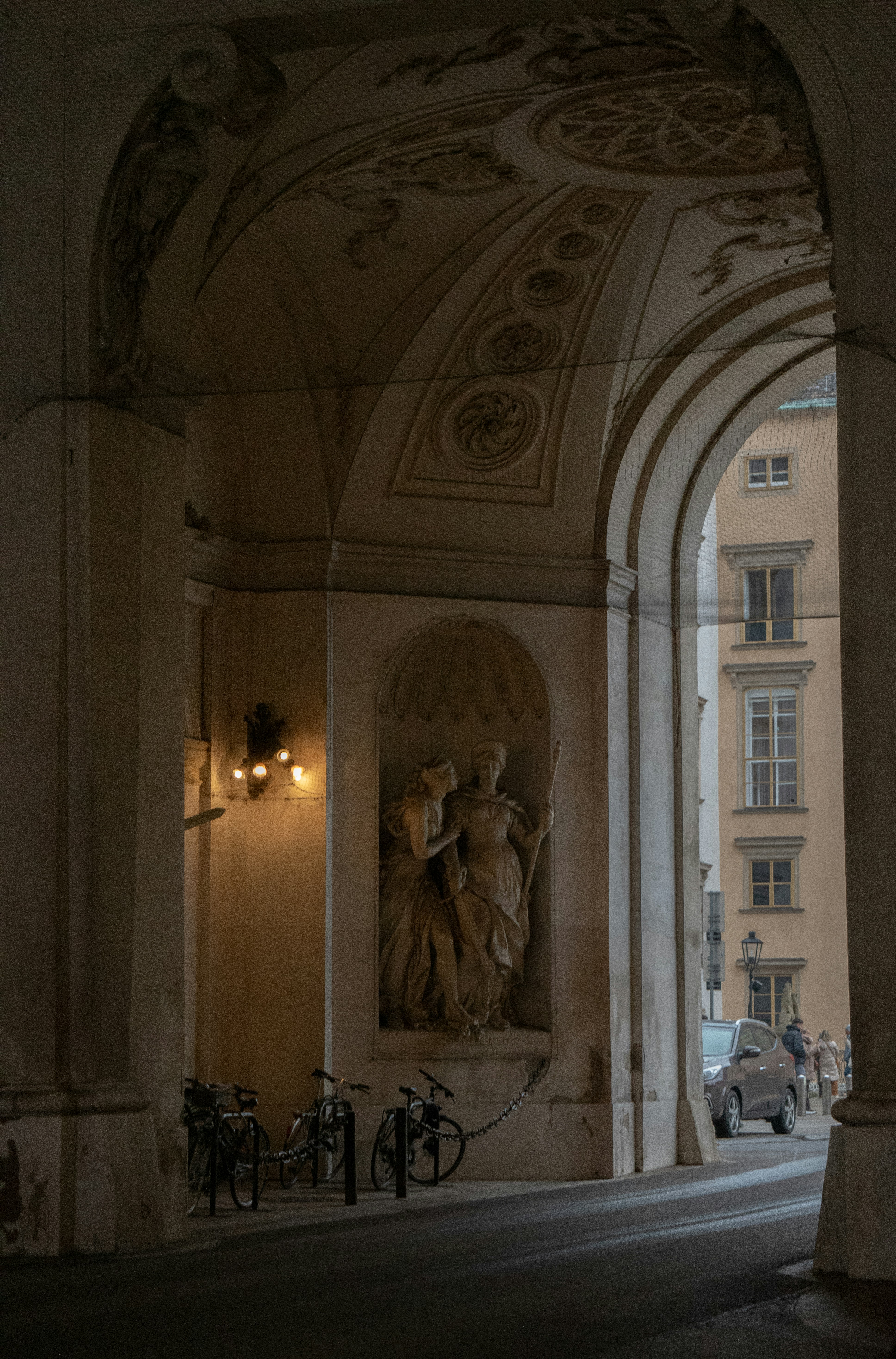 Archway Grace: Sculpted Figures Under Evening Light