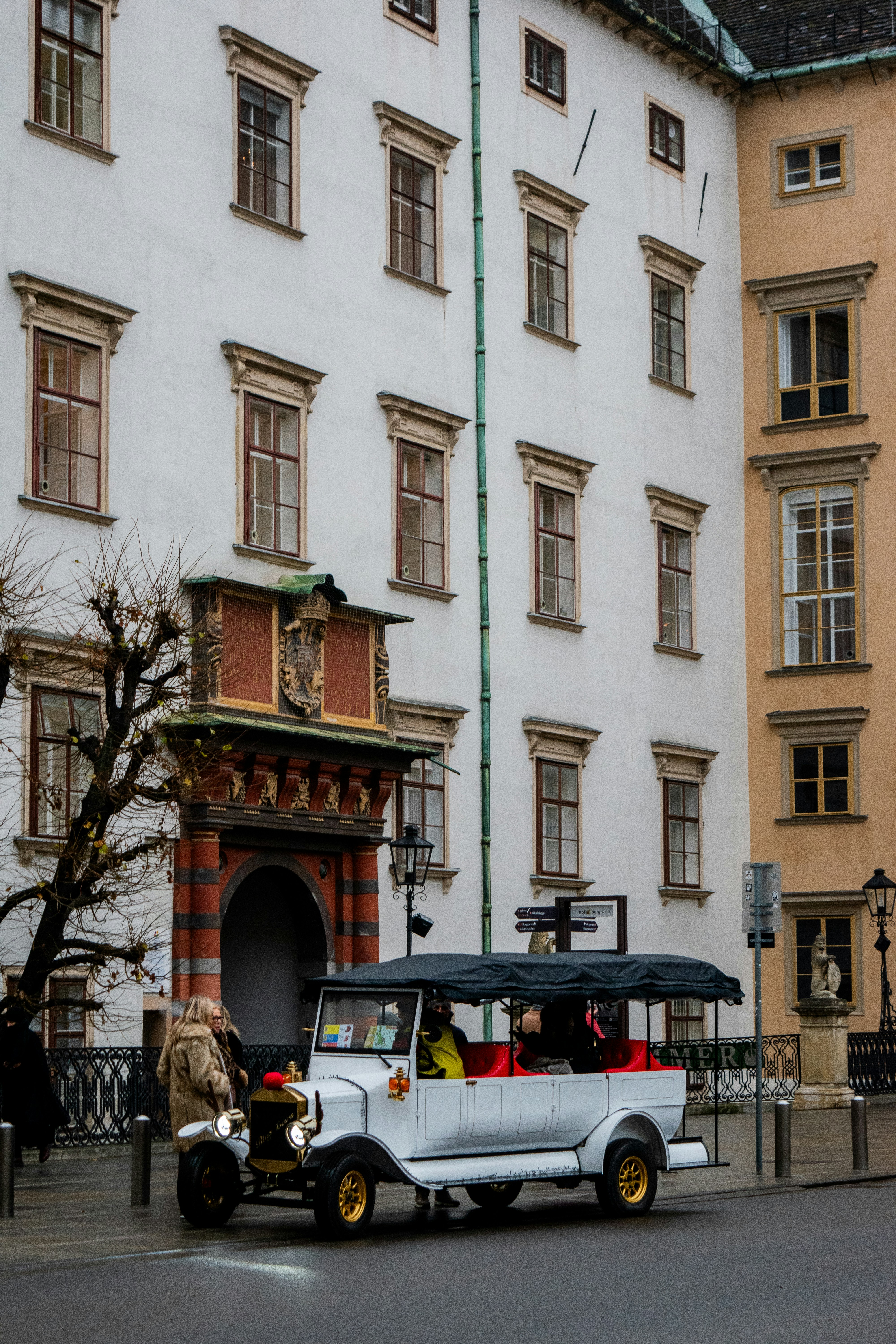 Vintage Tour on a cobblestone street before a pastel facade