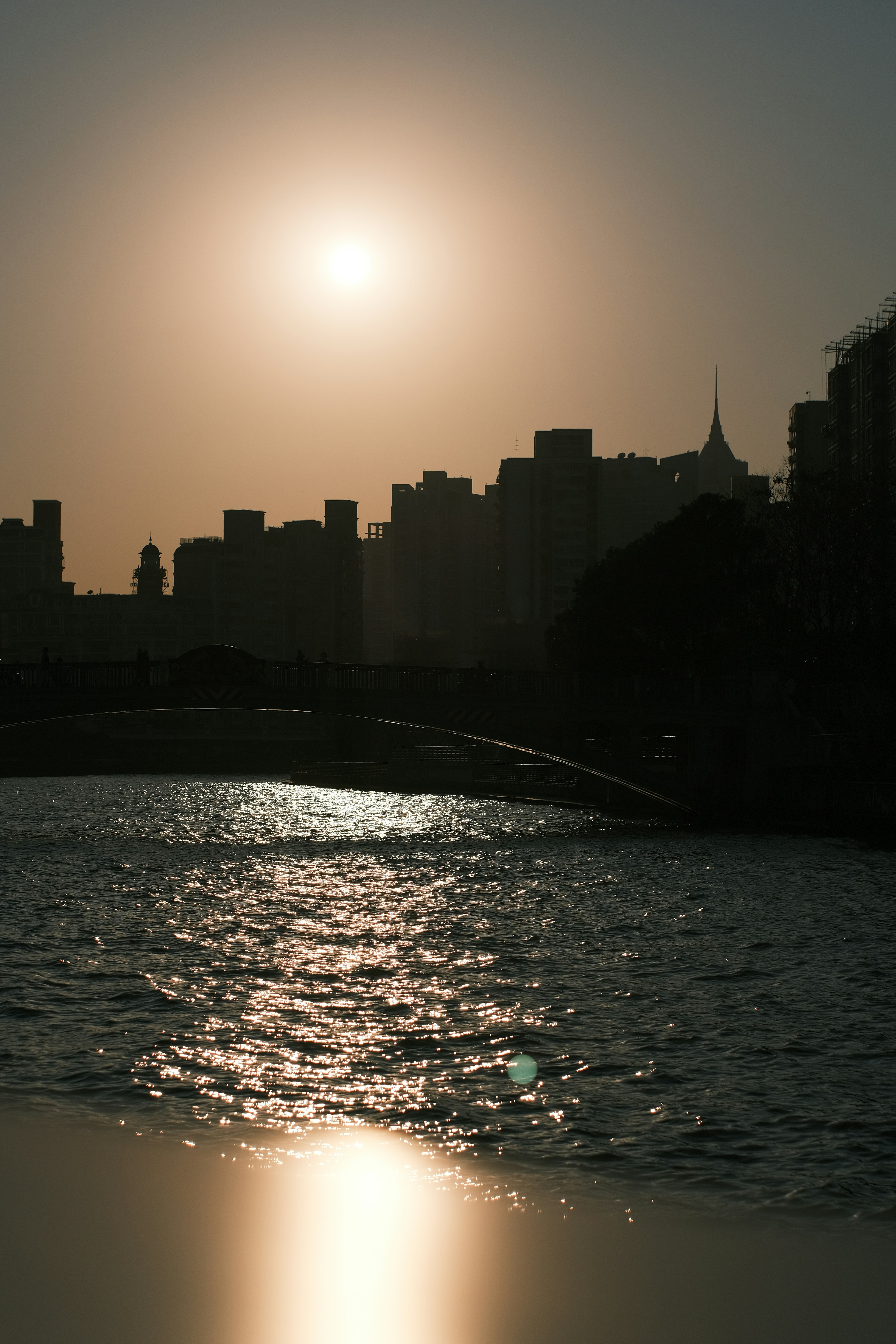 Golden Hour Over the River: City Silhouette and Reflective Water