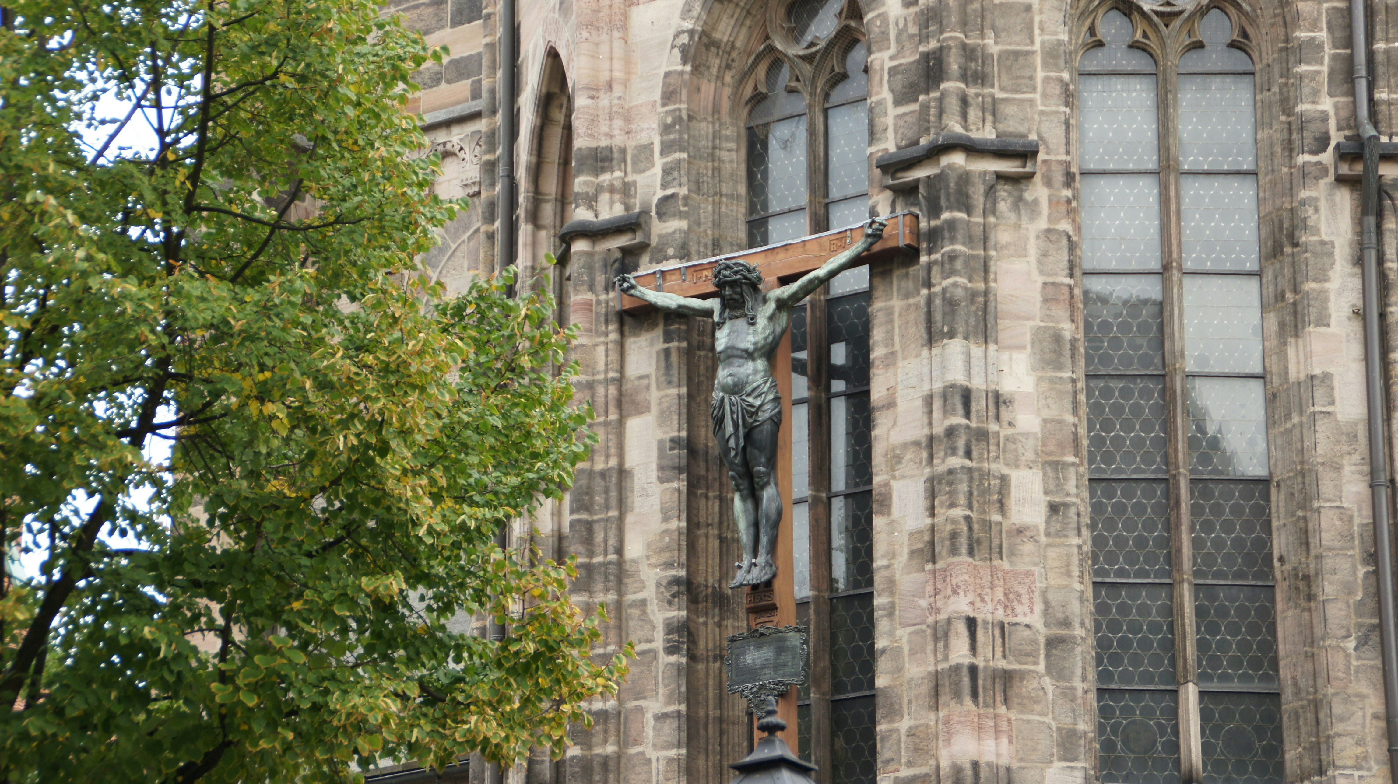Crucifixion over Gothic Facade: statue rising beside stained windows