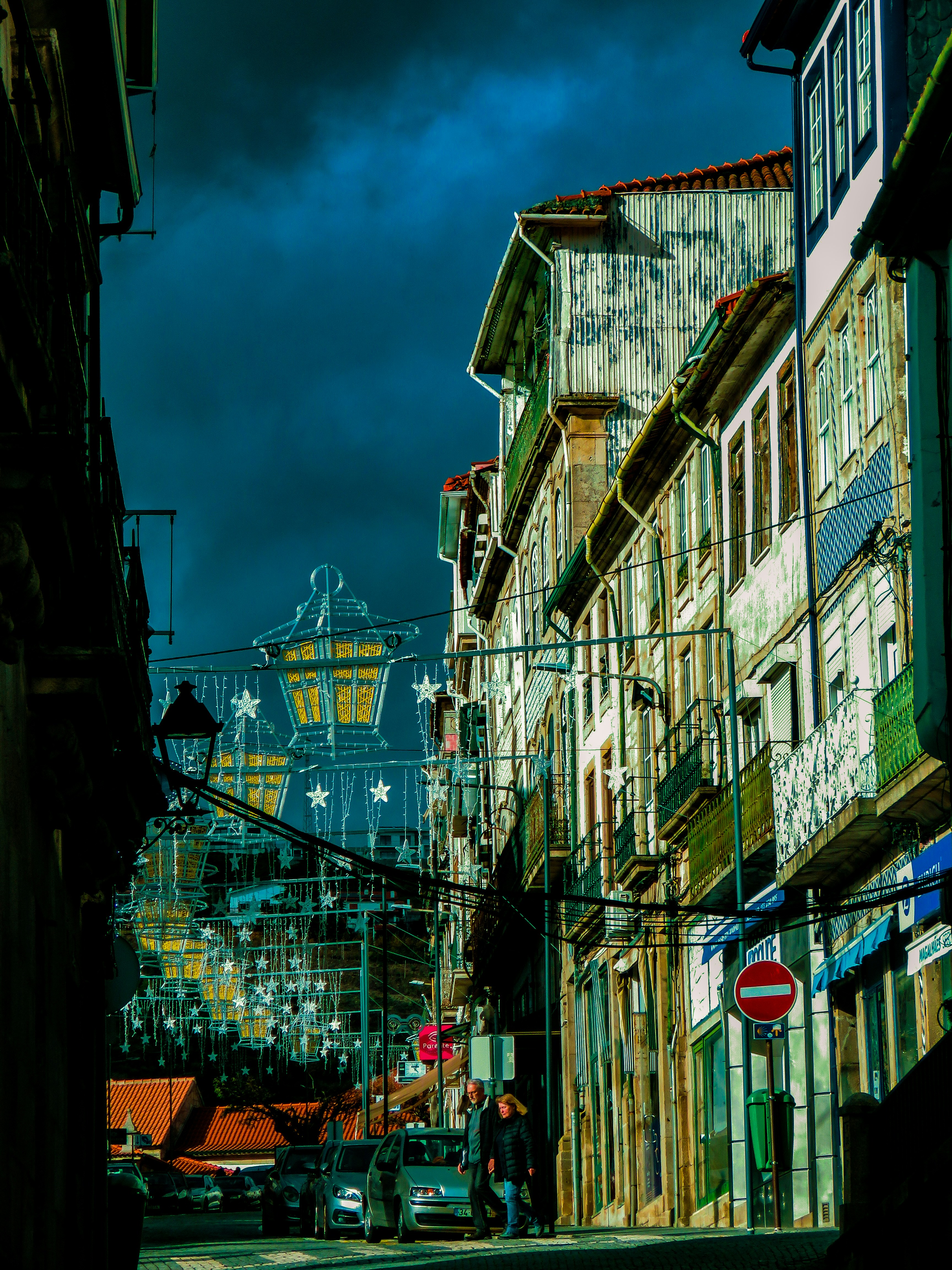Lantern-lit Street of Facades Under a Stormy Hue