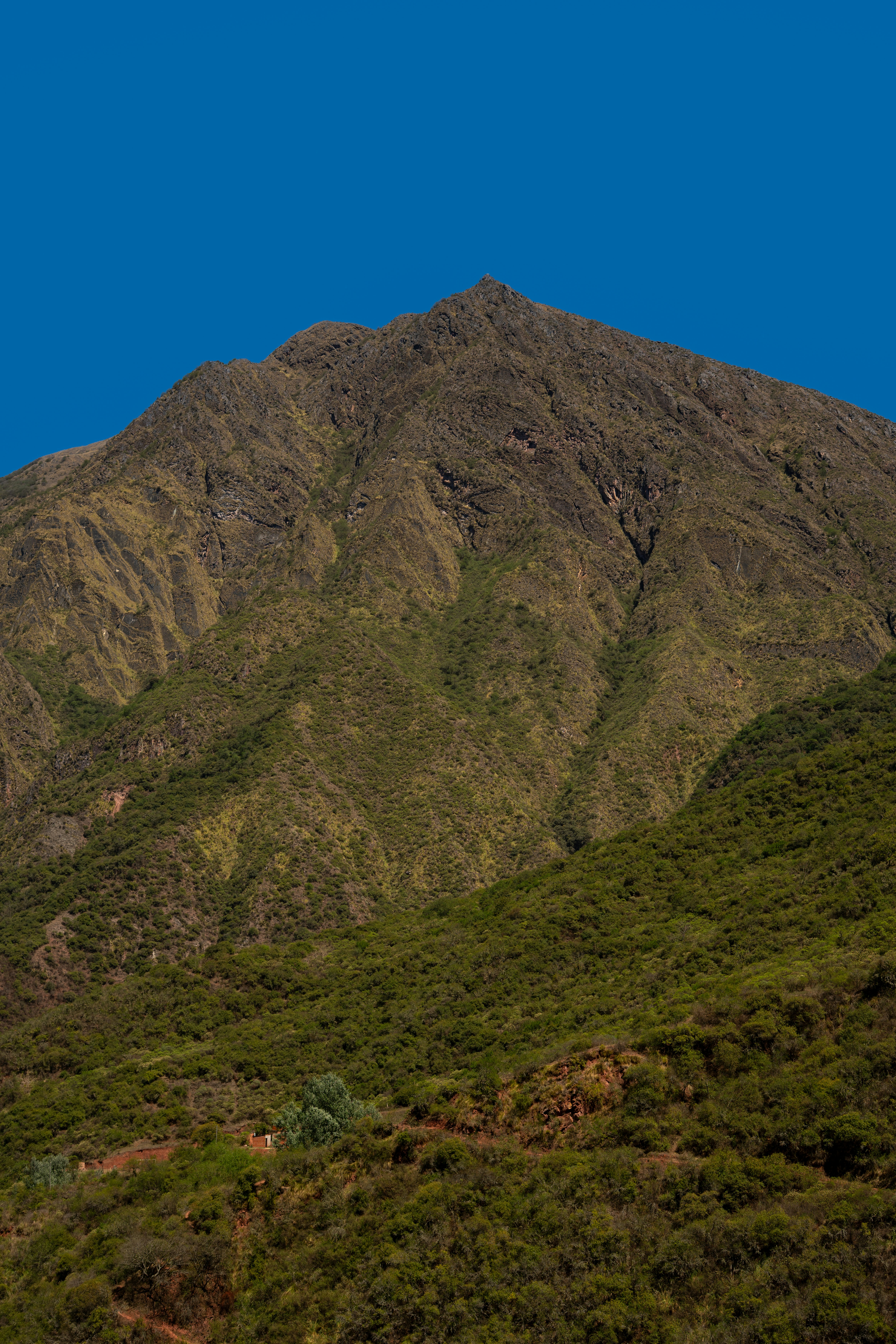 A blend of green slopes and rocky terrain creating a simple yet striking mountain landscape.