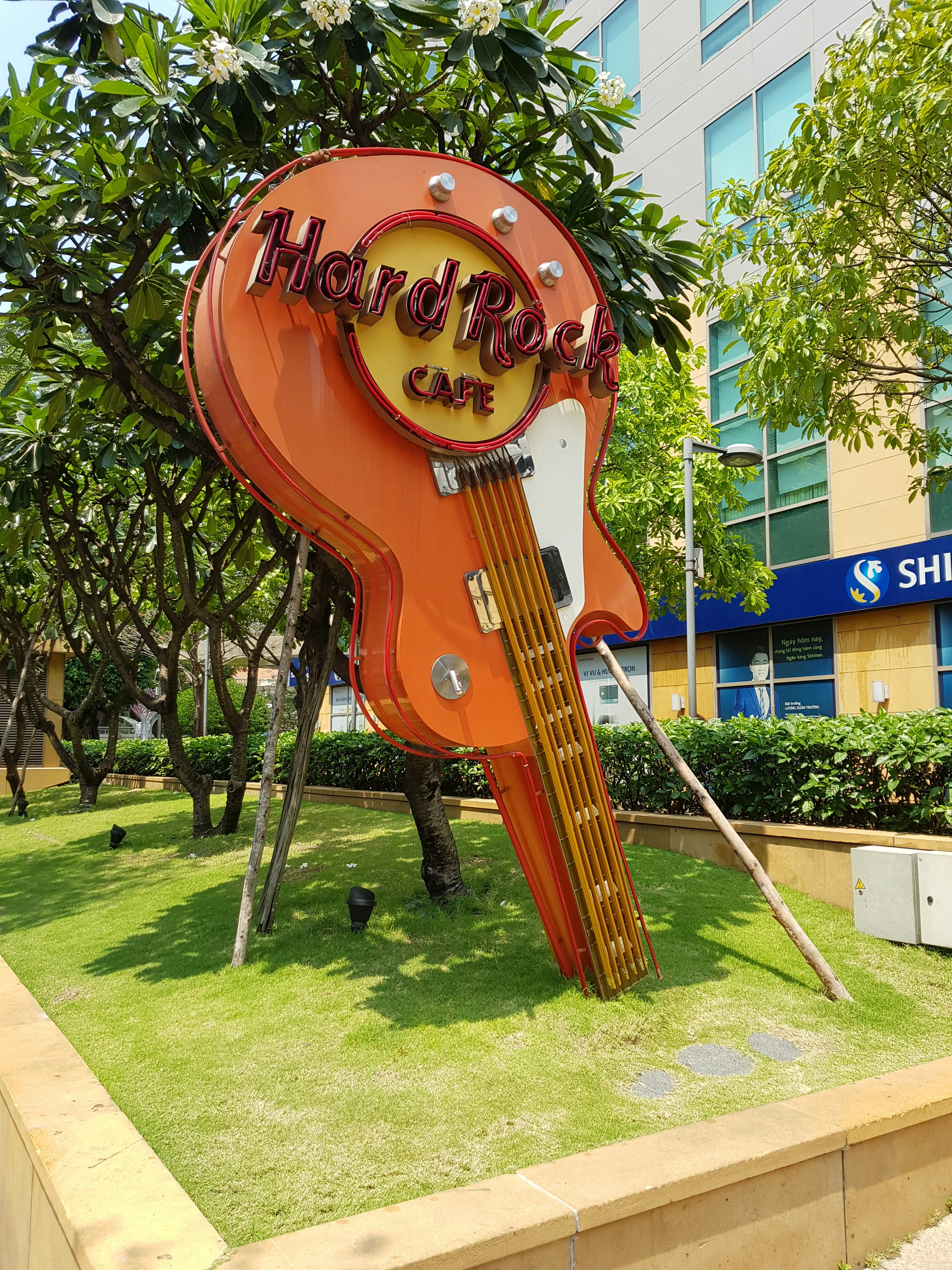 Giant guitar statue anchors the Hard Rock Café exterior amid urban greenery