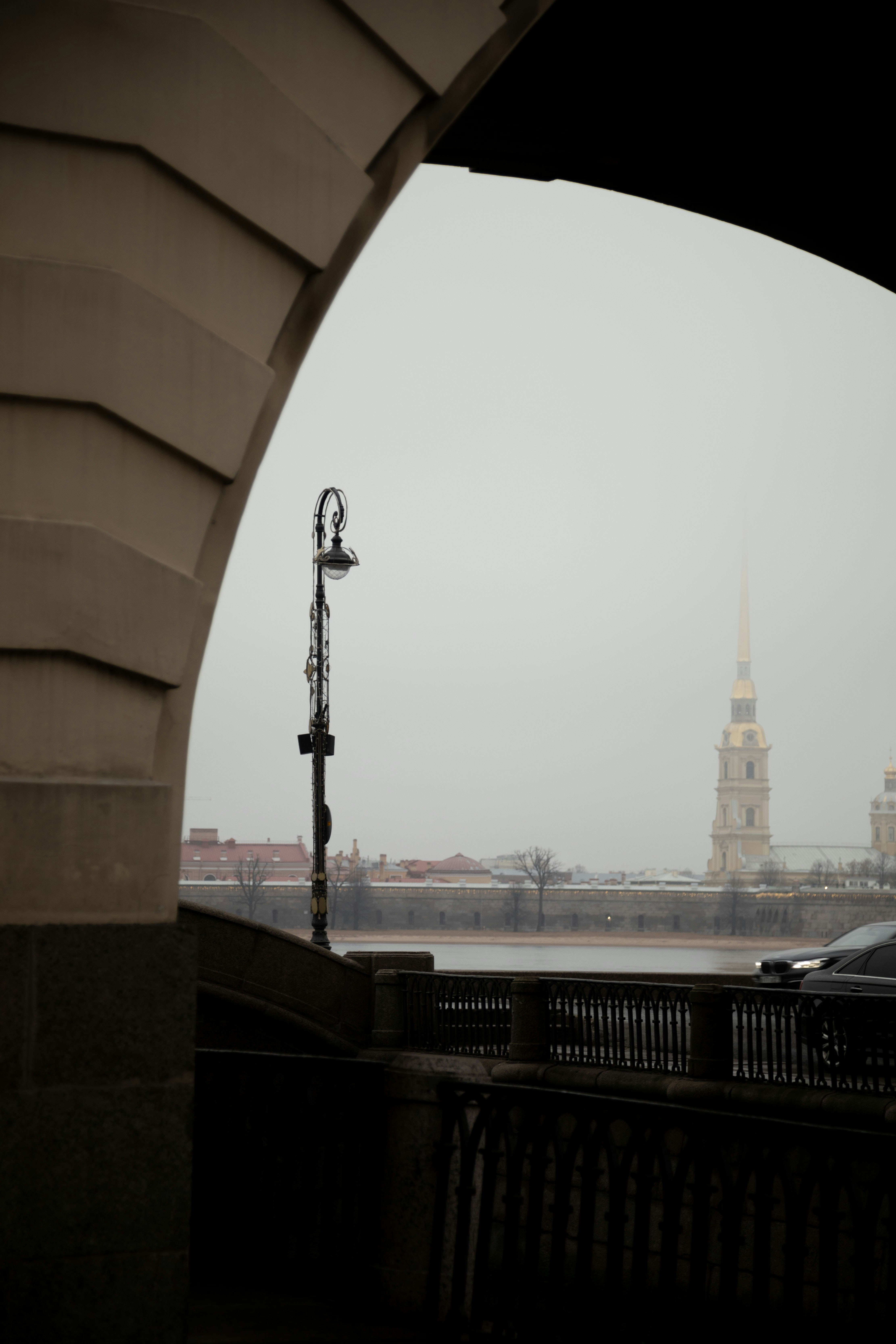 Arc of Shadow and Spire: City Overlook Through a Stone Frame
