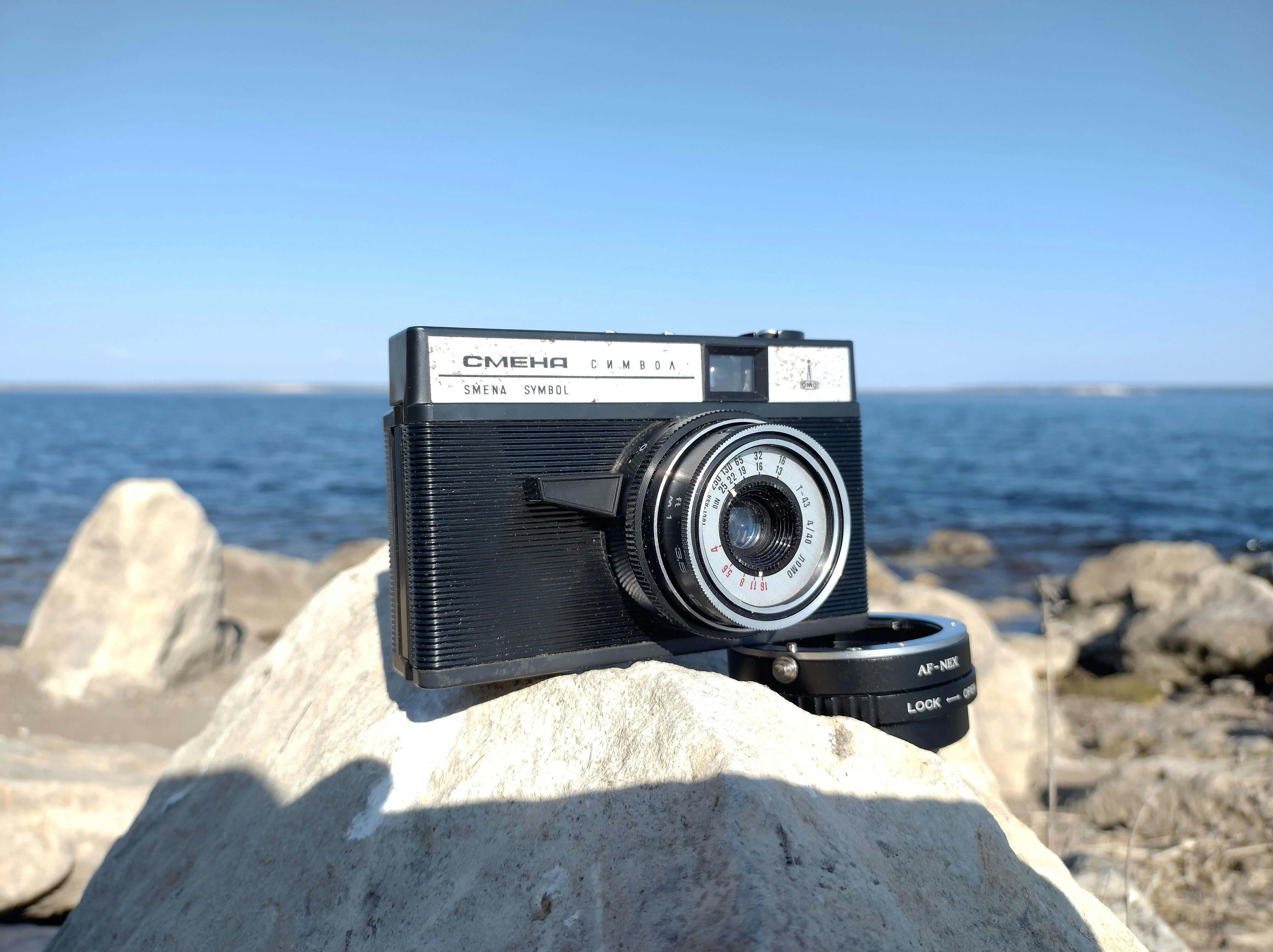 Smena-Symbol, an old Soviet camera, on a stone on a beach