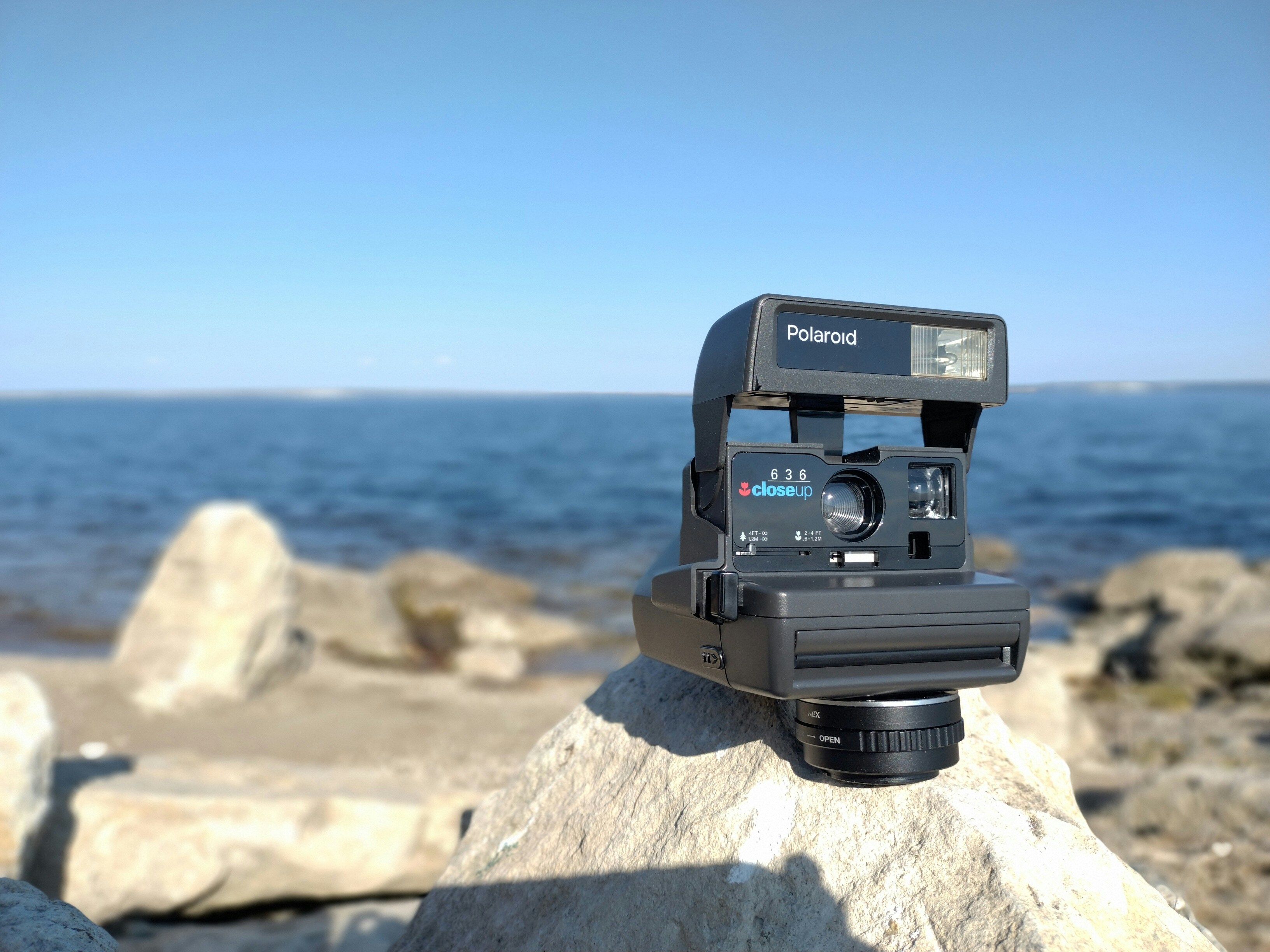 Polaroid 636 camera on a stone on a beach