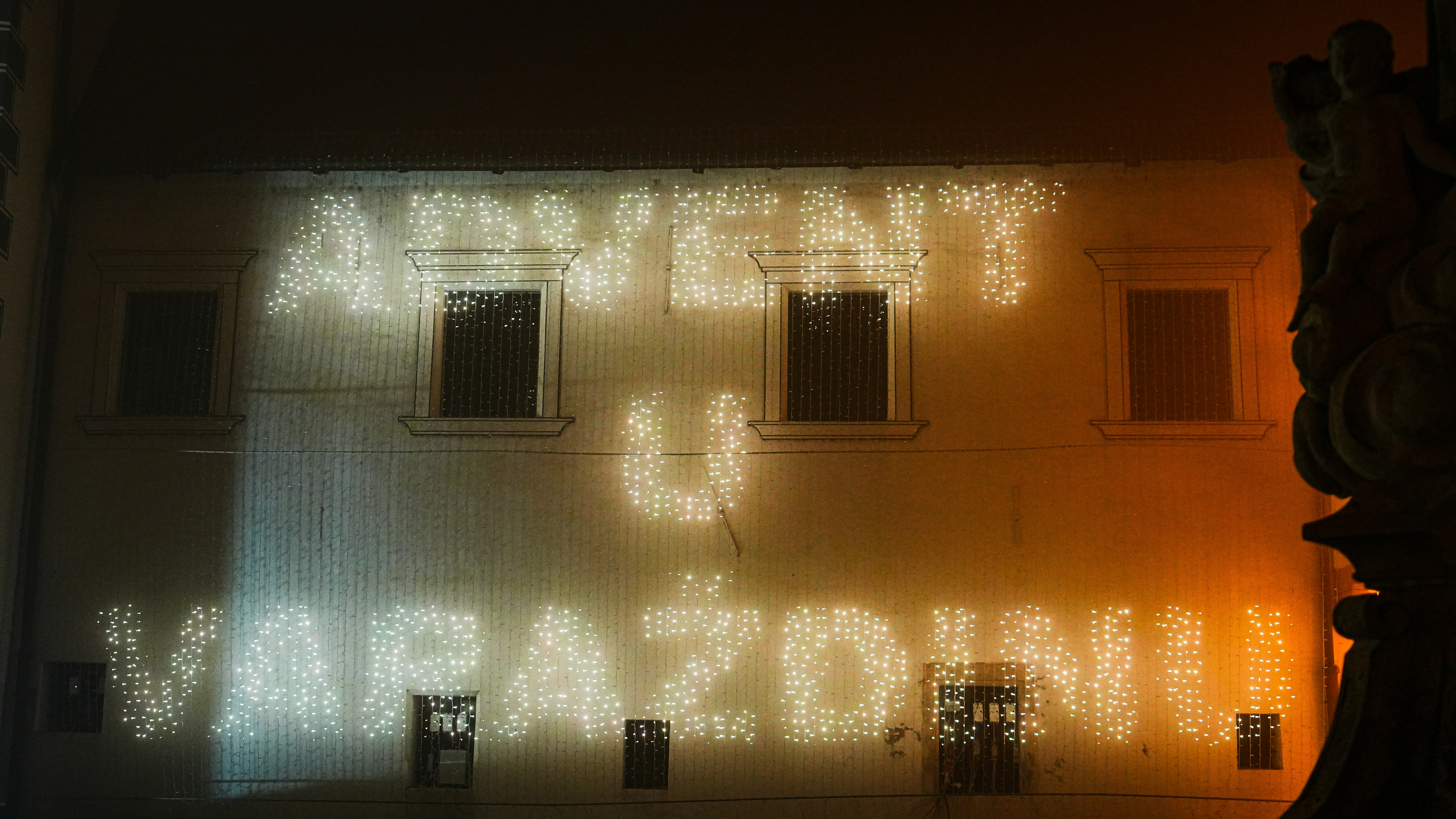 Glowing Messages Spill Across the Facade