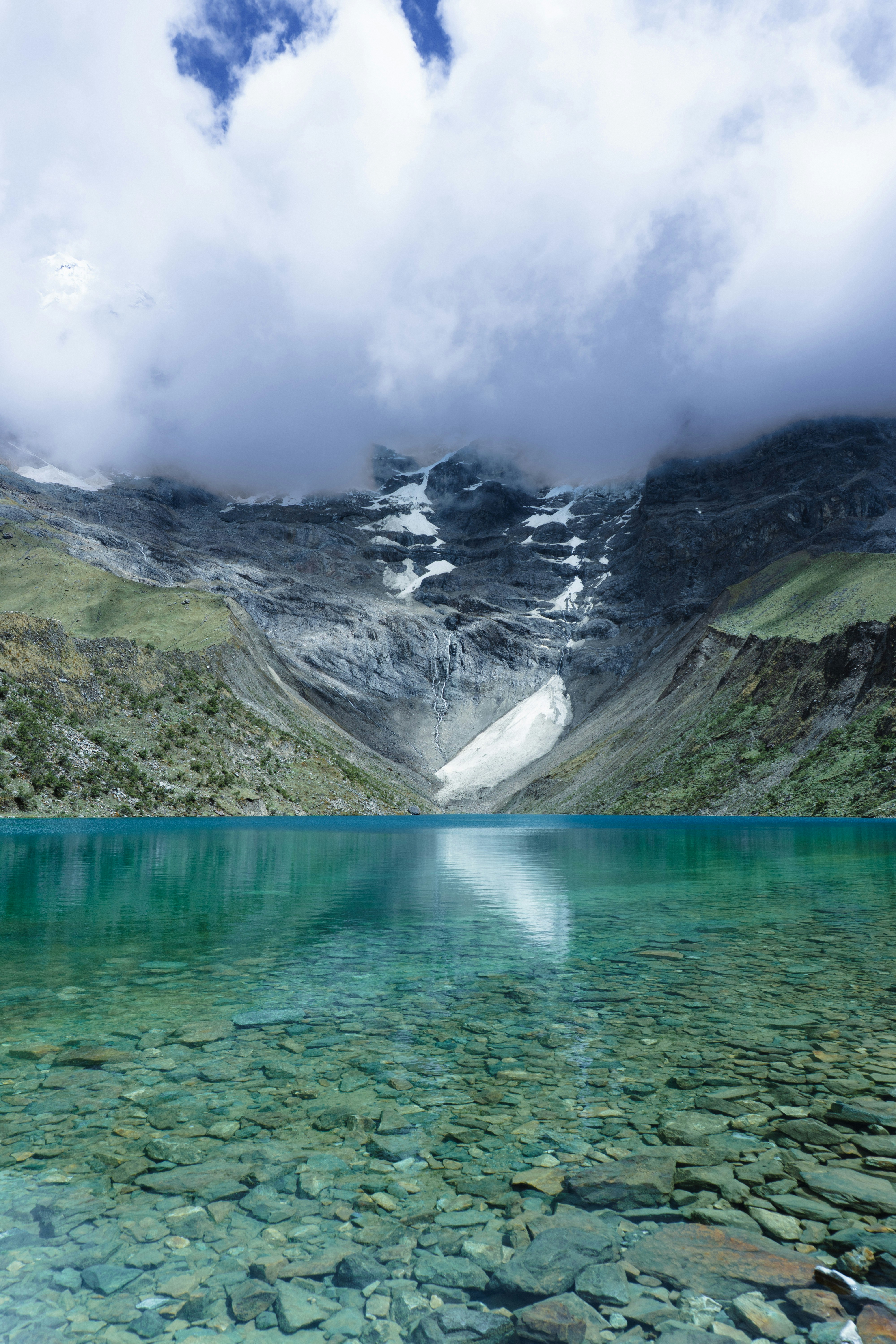 Emerald Mirror: Glacier-fed Lake Beneath A Cloud-veiled Alpine Rim