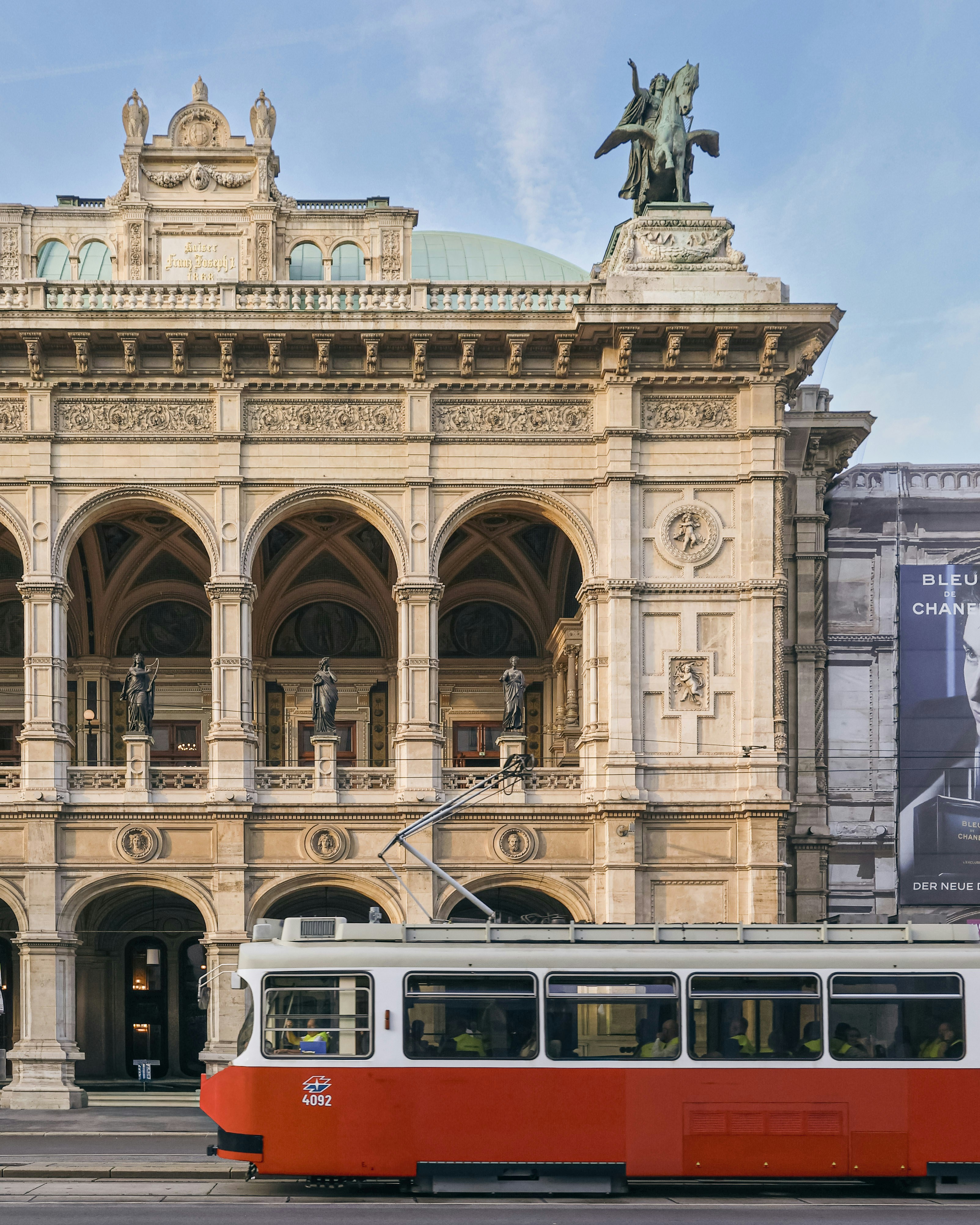 Heritage in Motion: A Red Tram Cleaves the Grand Facade