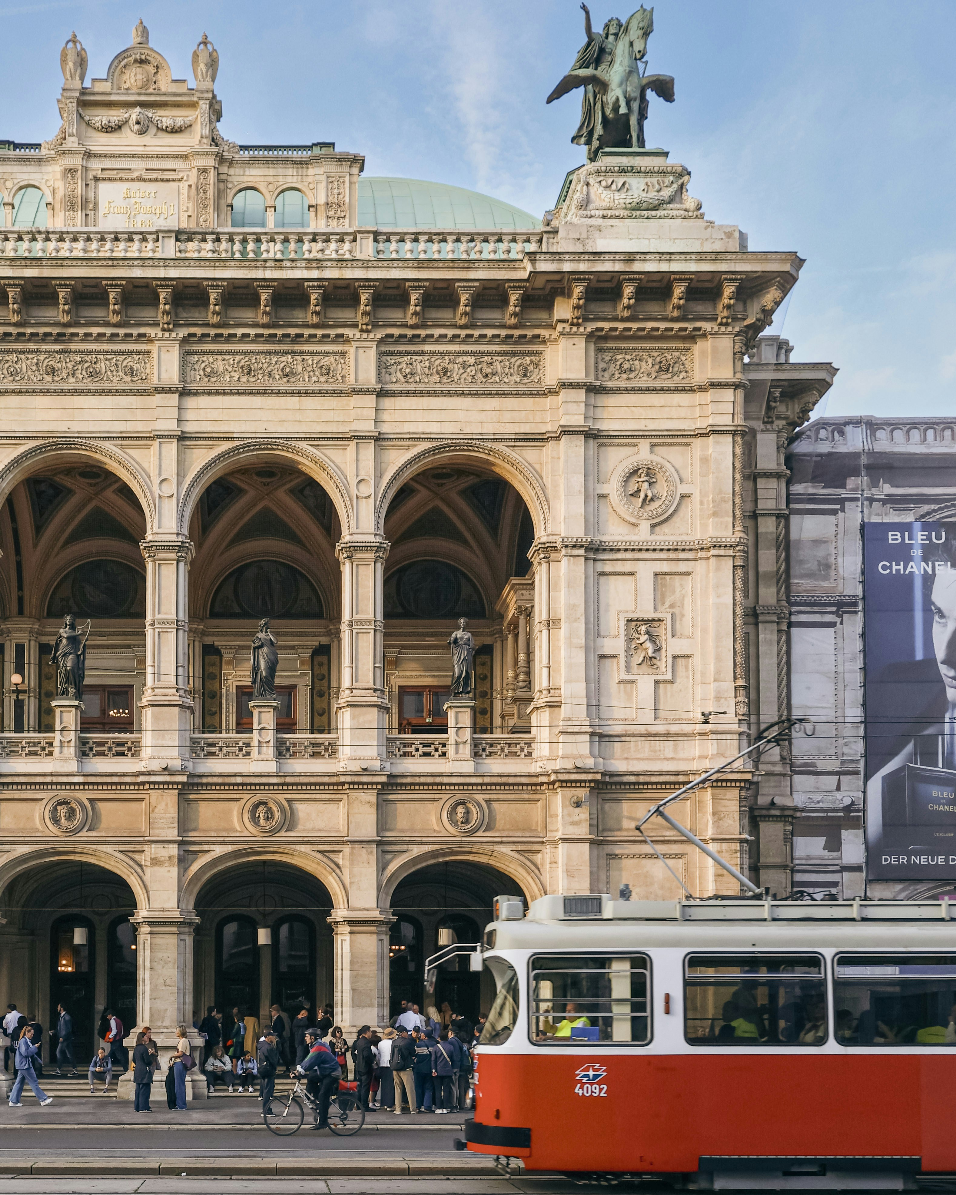 Clay-red Tram at the Grand Palais: A Moment Before the Sweep of Steel and Stone