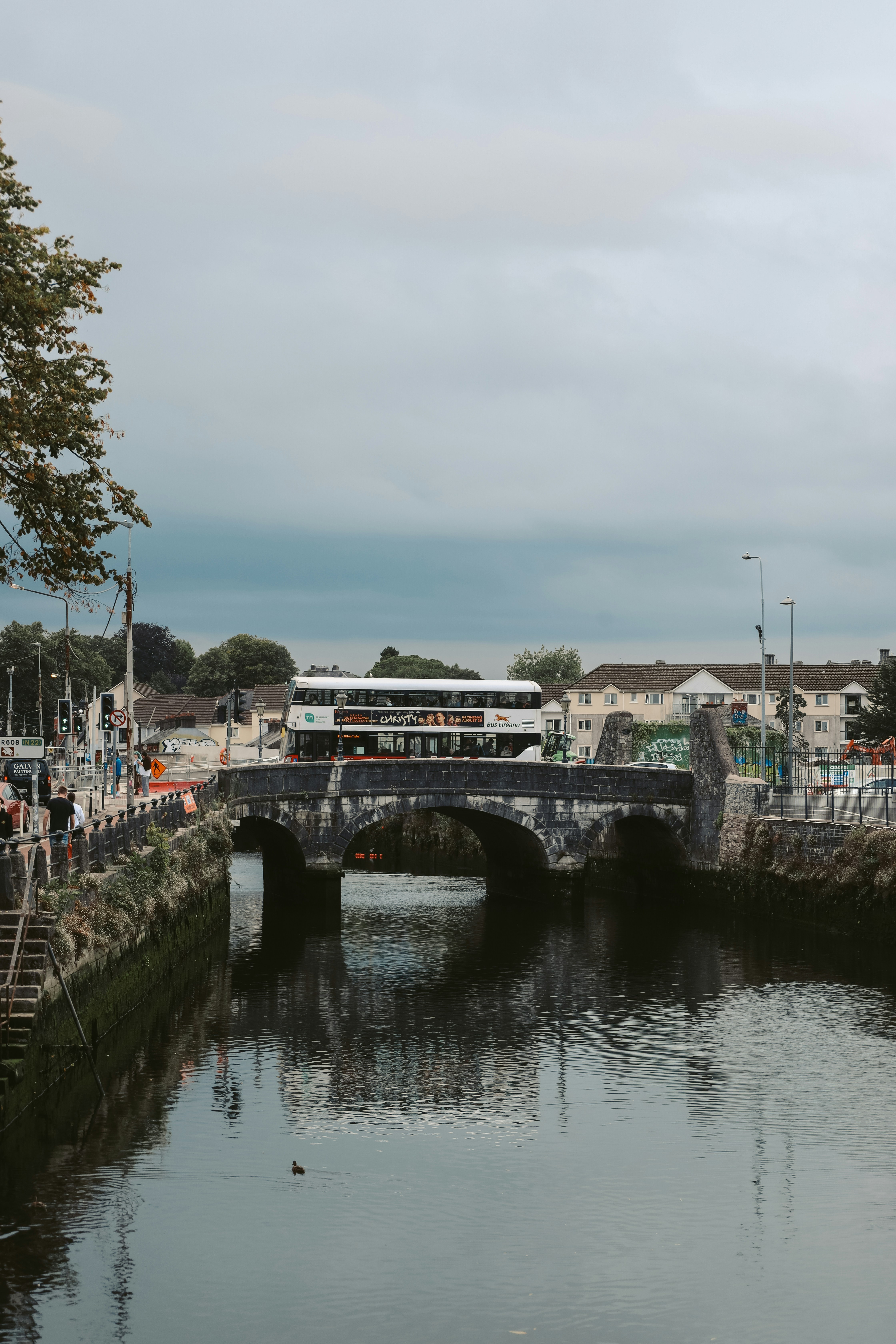 City Canal: A Double-Decker Bus Crossing the Historic Stone Bridge