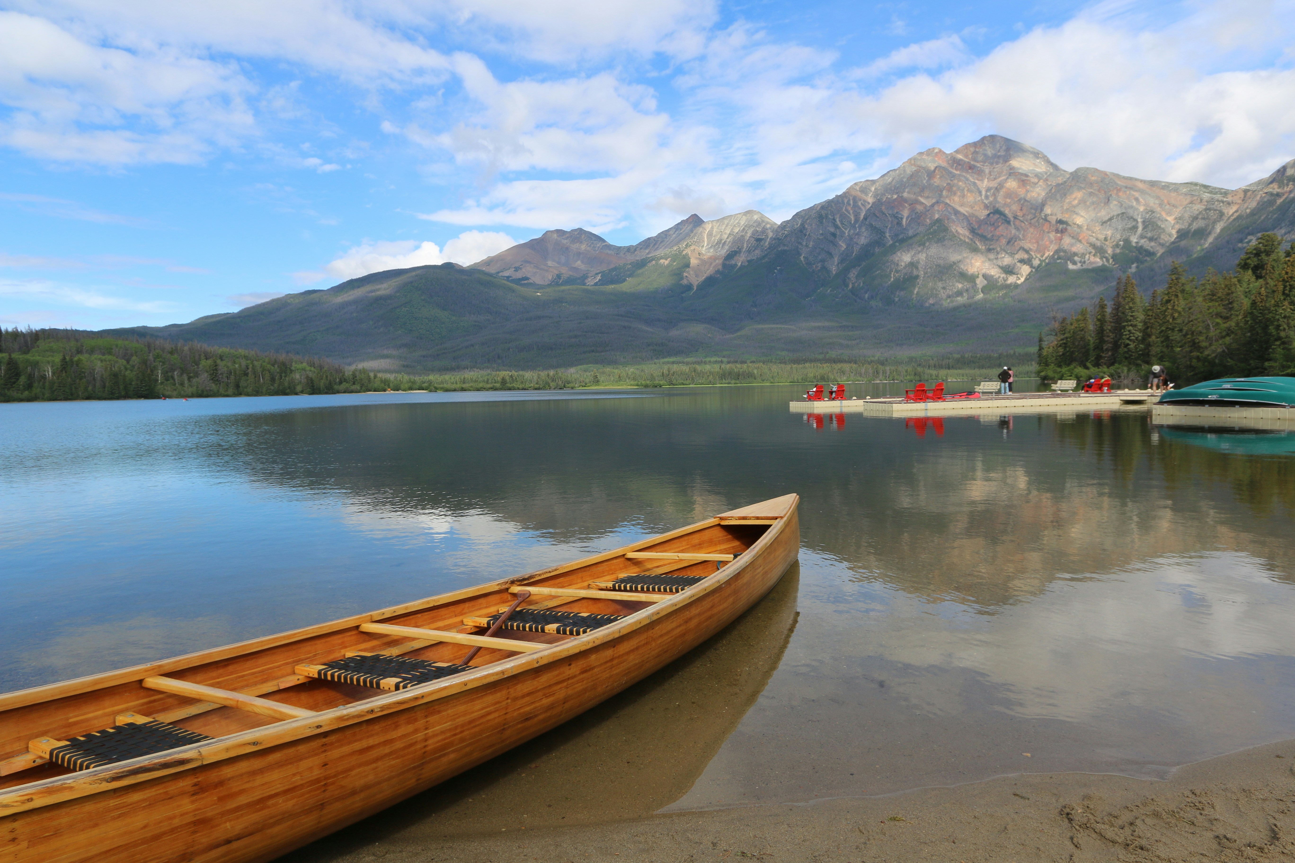 Wooden Boat at the Edge of a Mirror-Calm Mountain Lake
