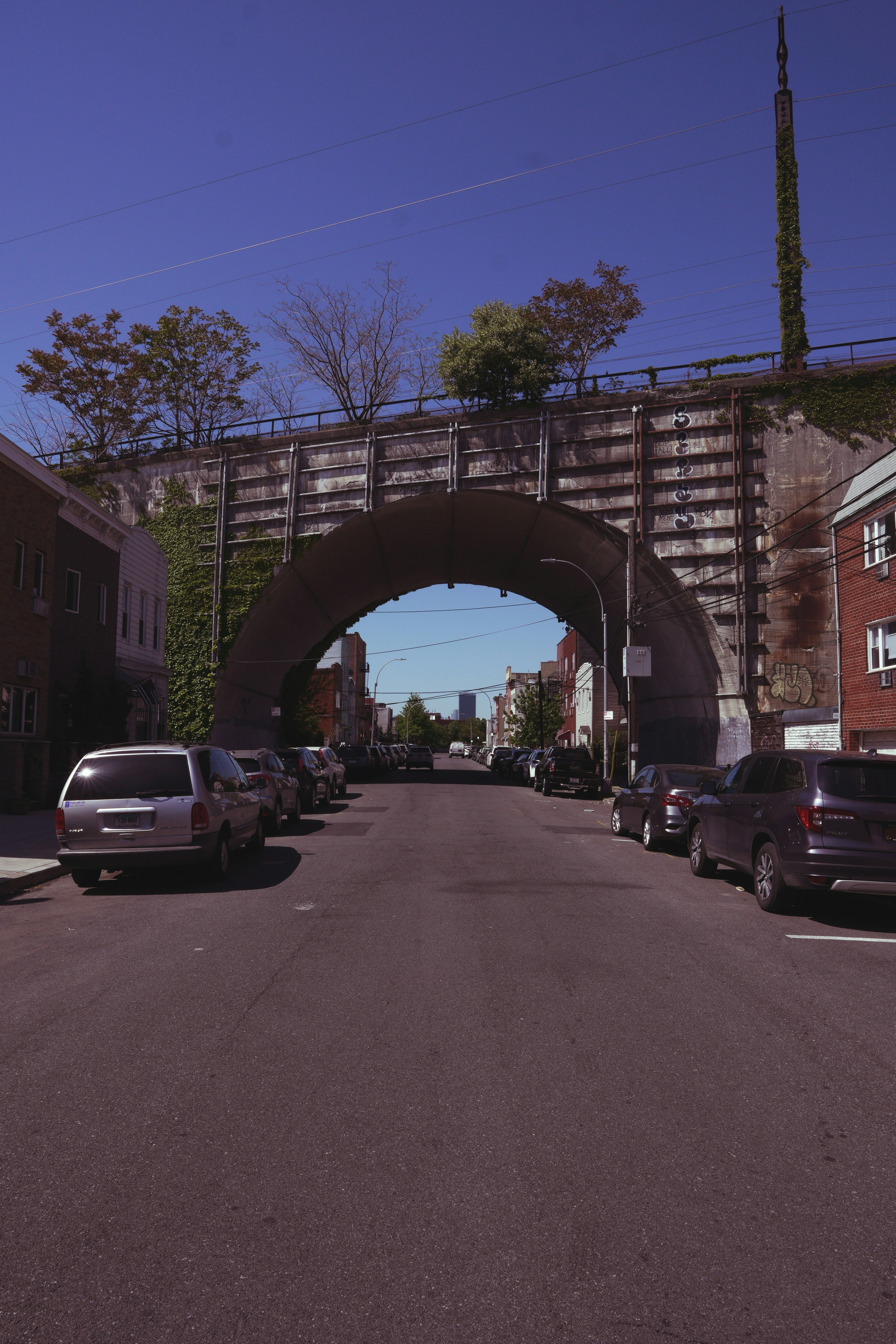 Under the Rail Arch: A Quiet Street Reaches Toward the City