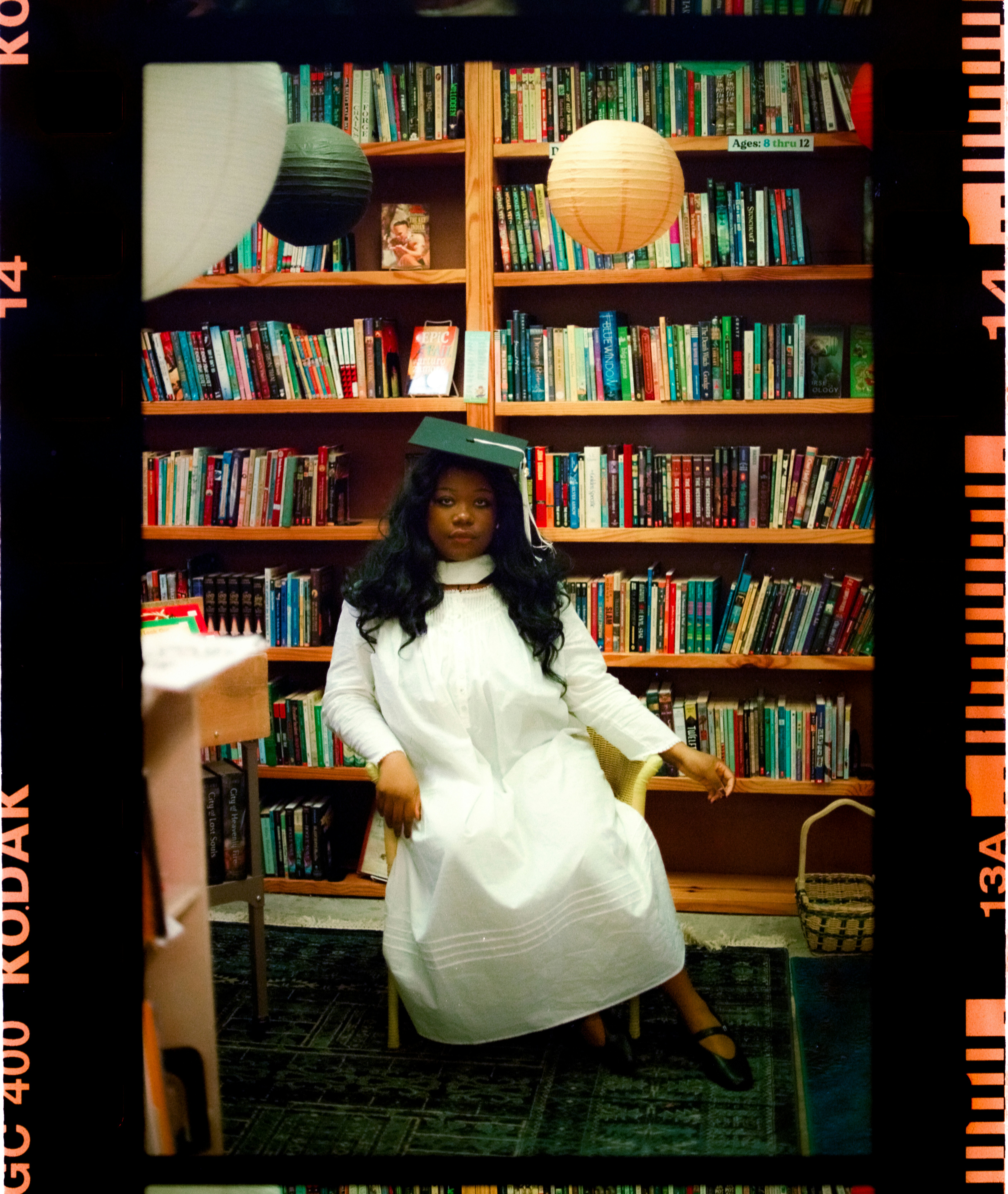 Graduation Moments in a Library: A Portrait Beneath Hanging Lanterns