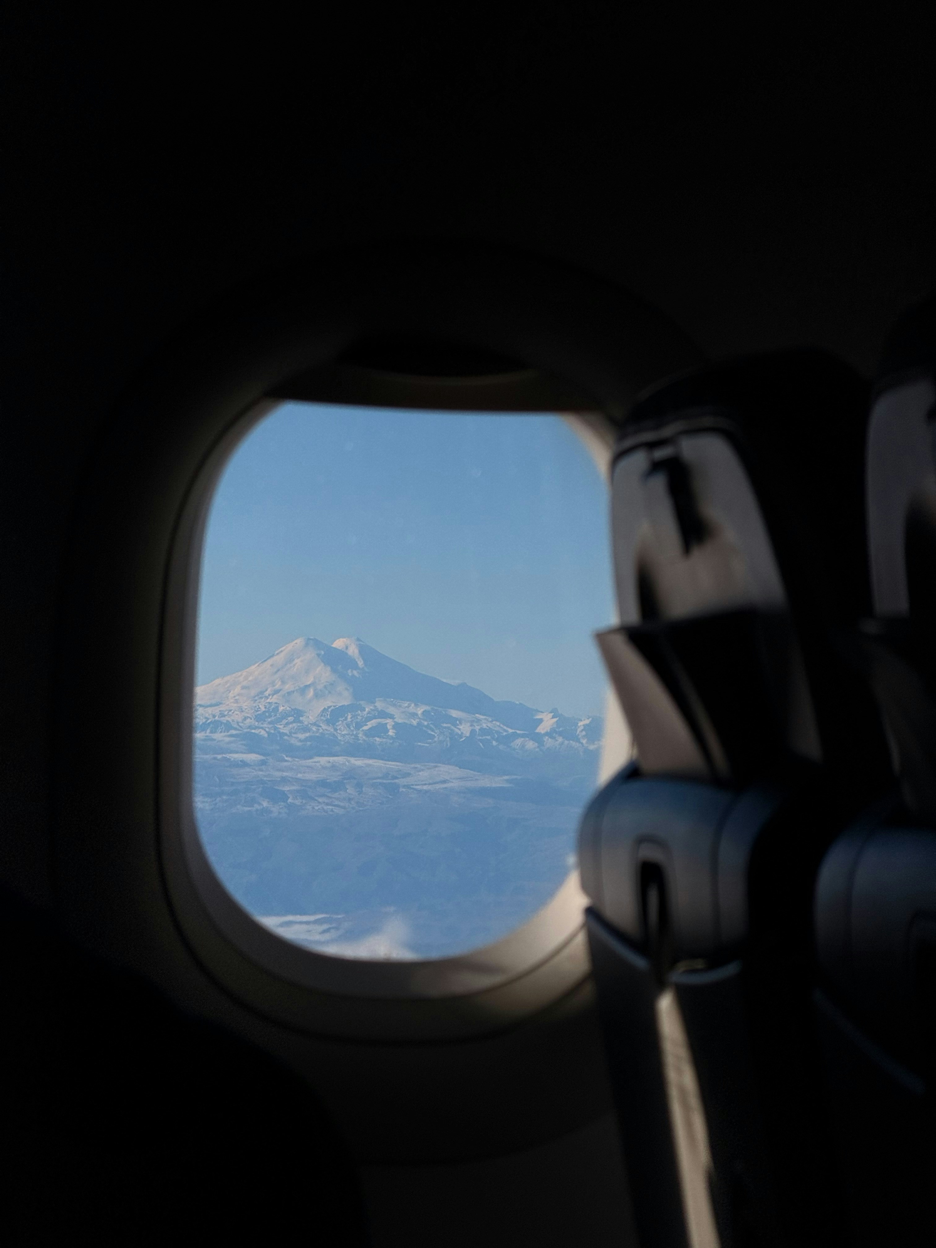 Snow-capped Peak Framed by Airplane Window