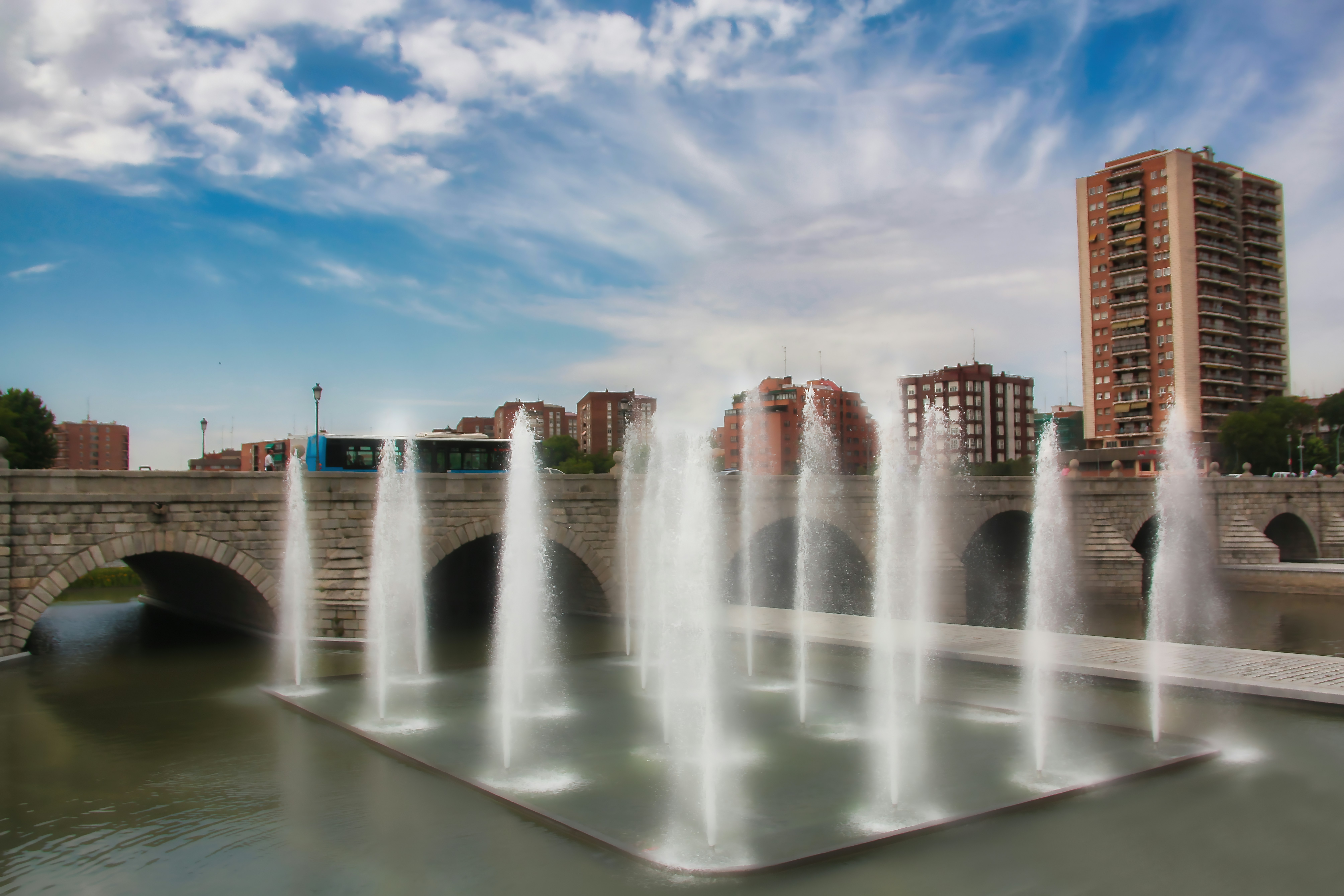 Jet Prisms Over the River: Modern City Fountains Under a Bright Sky