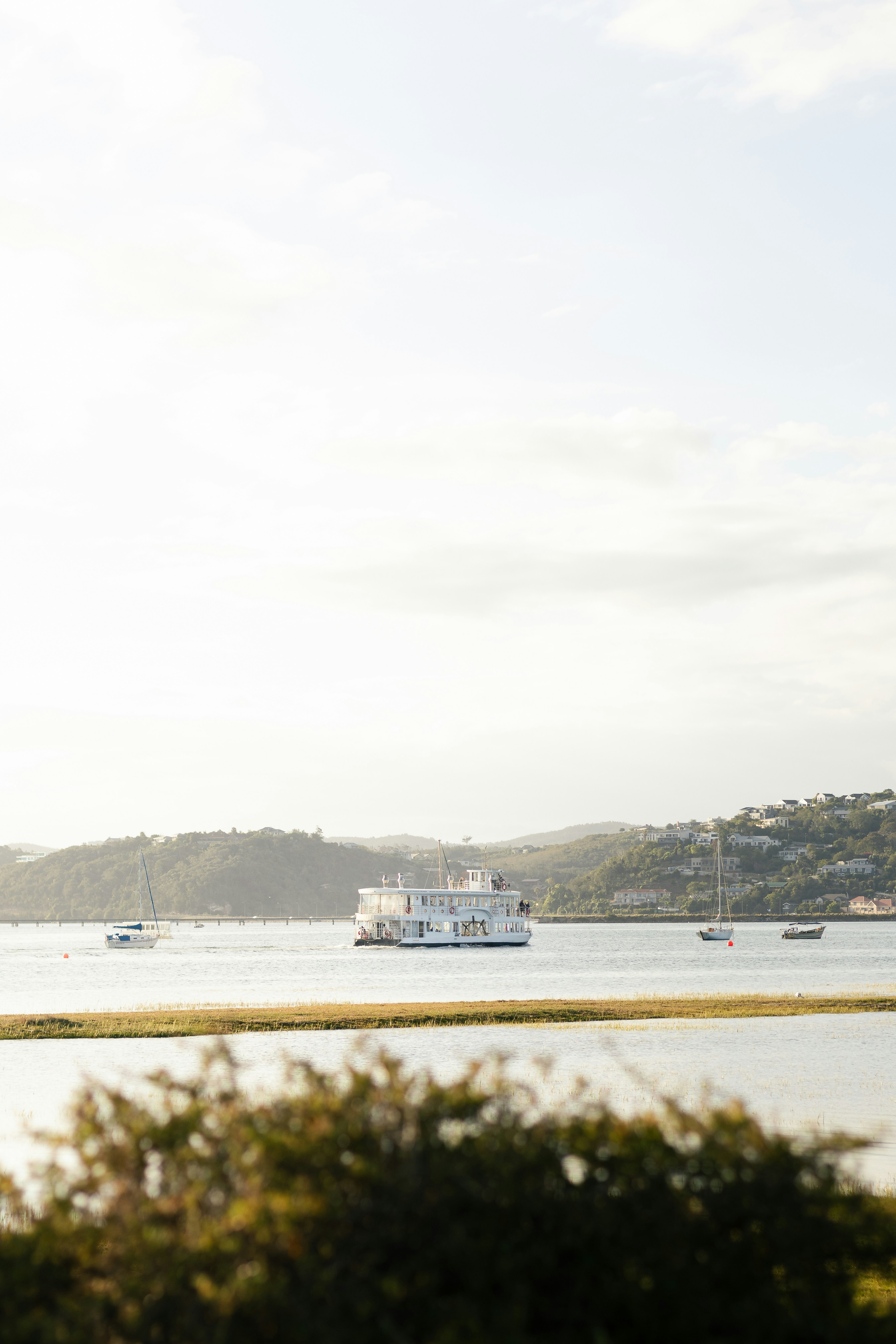 Quiet harbor at golden hour with a ferry and distant hills
