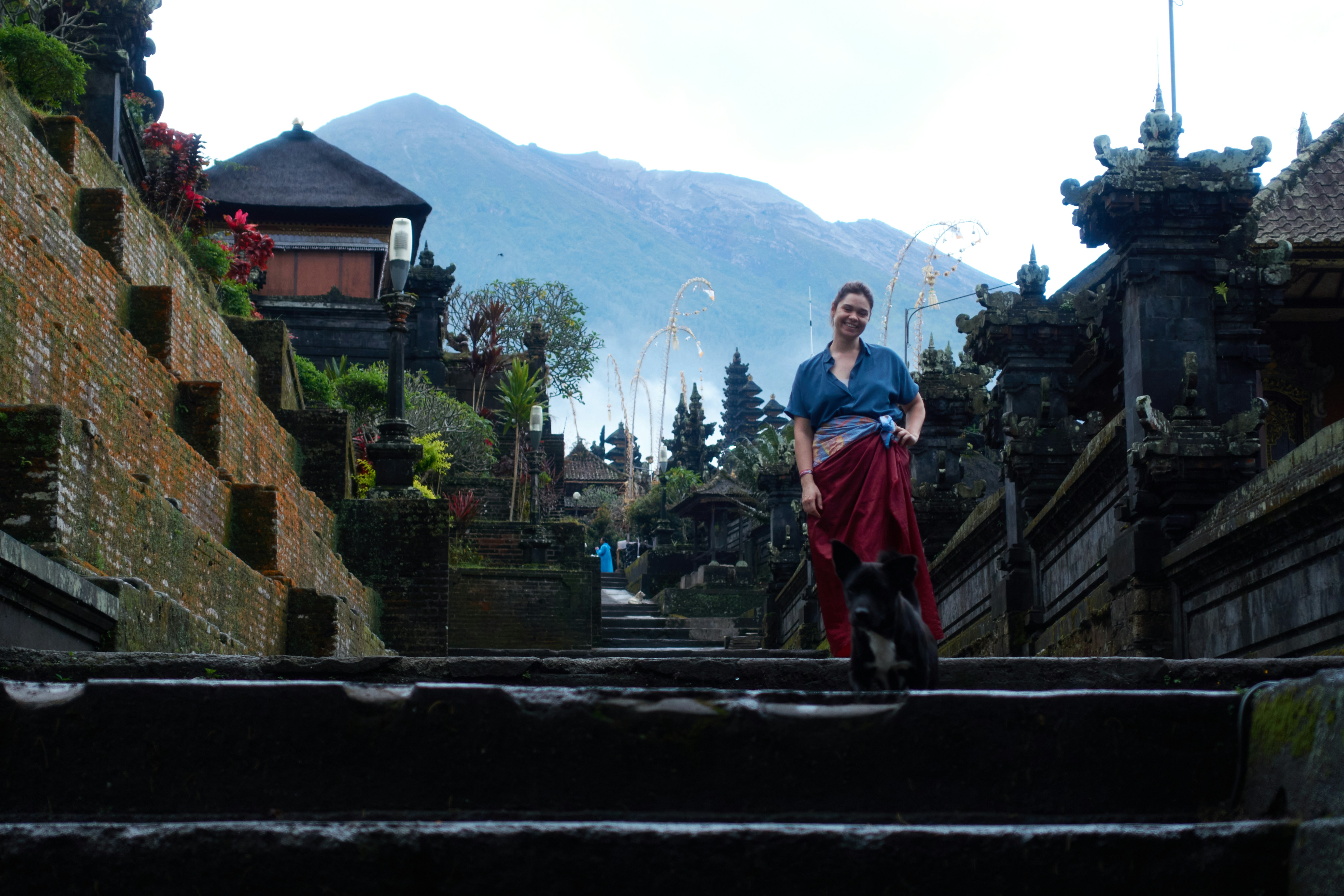 Temple stairs and traveler against a mountain backdrop