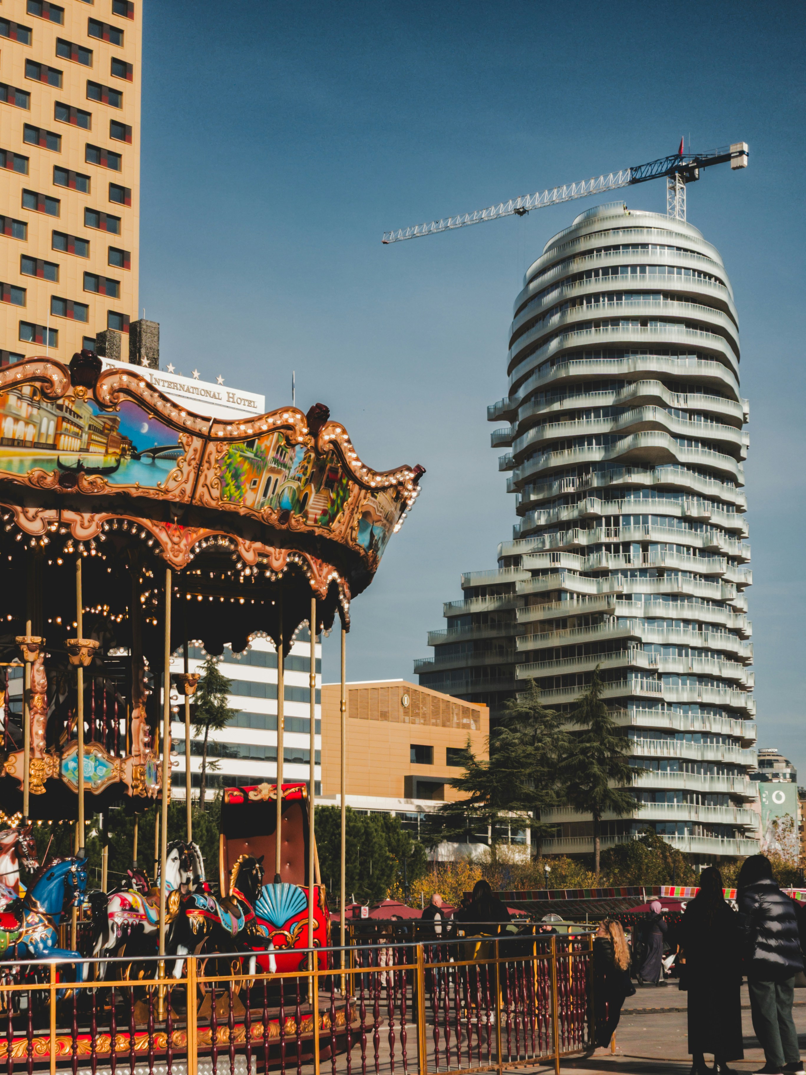 Carousel with modern building and crane