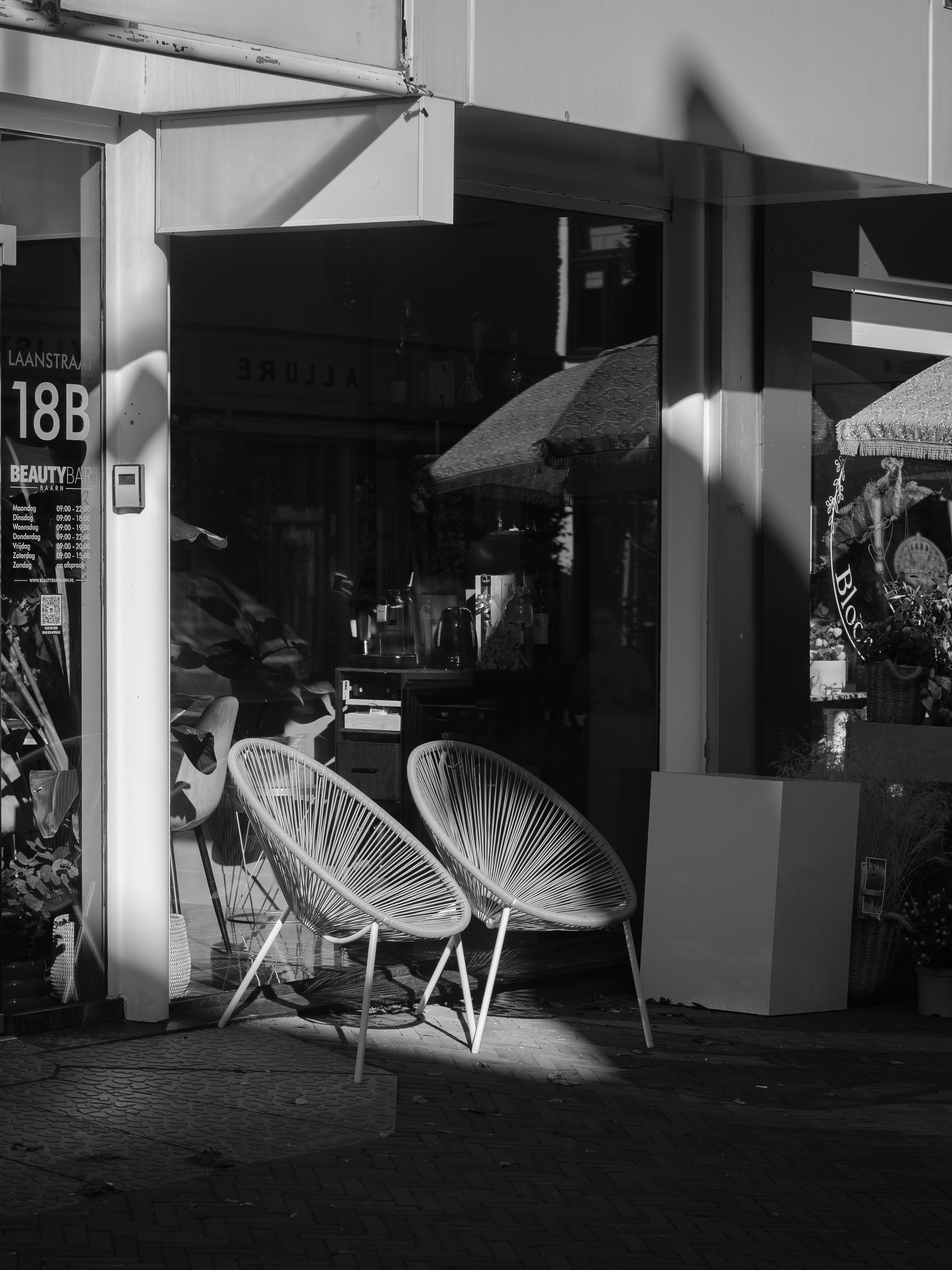 Quiet storefront chairs in the sunlit cafe alcove