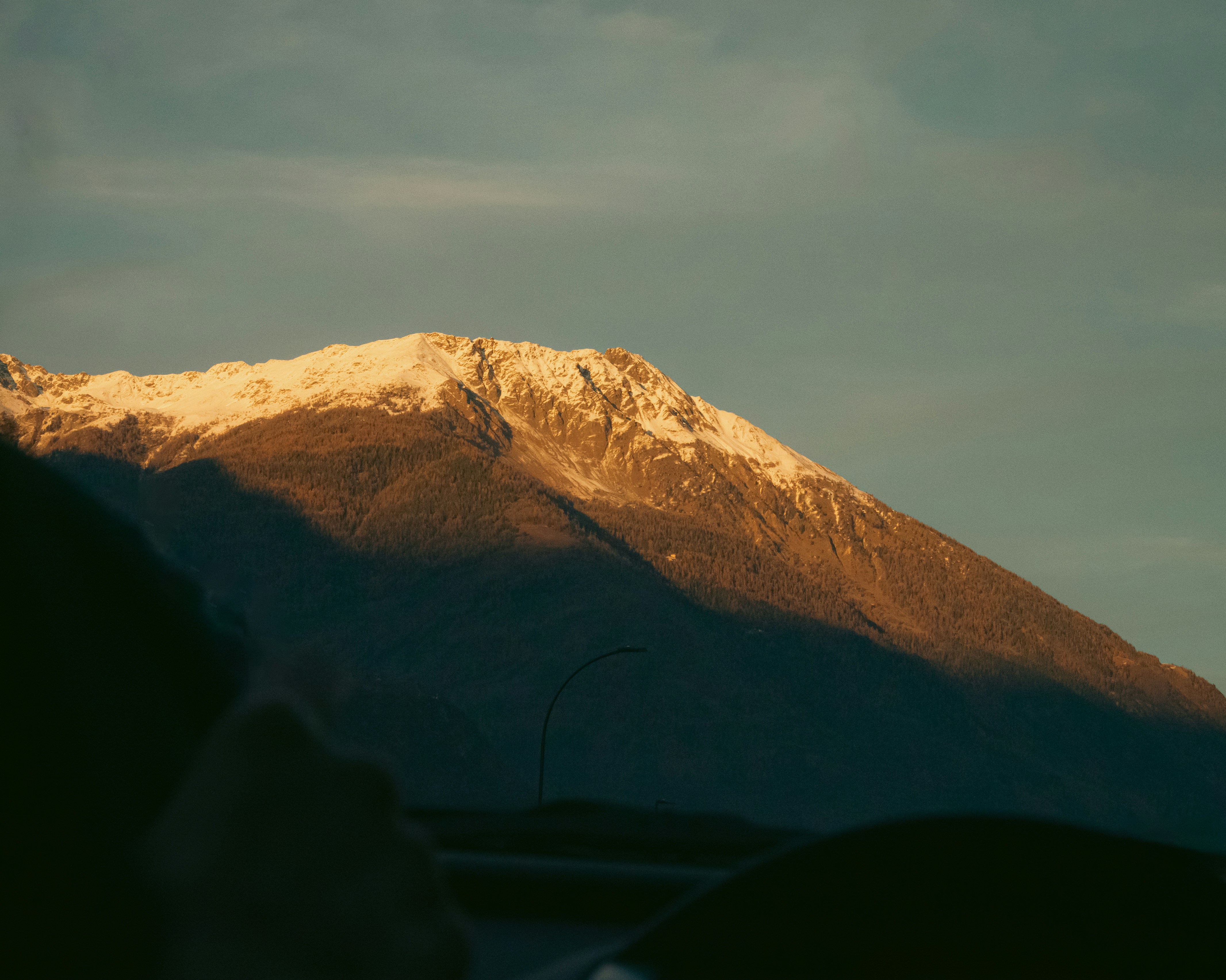 Golden Summit: Snow-capped Peak Bathes in Sunset Light