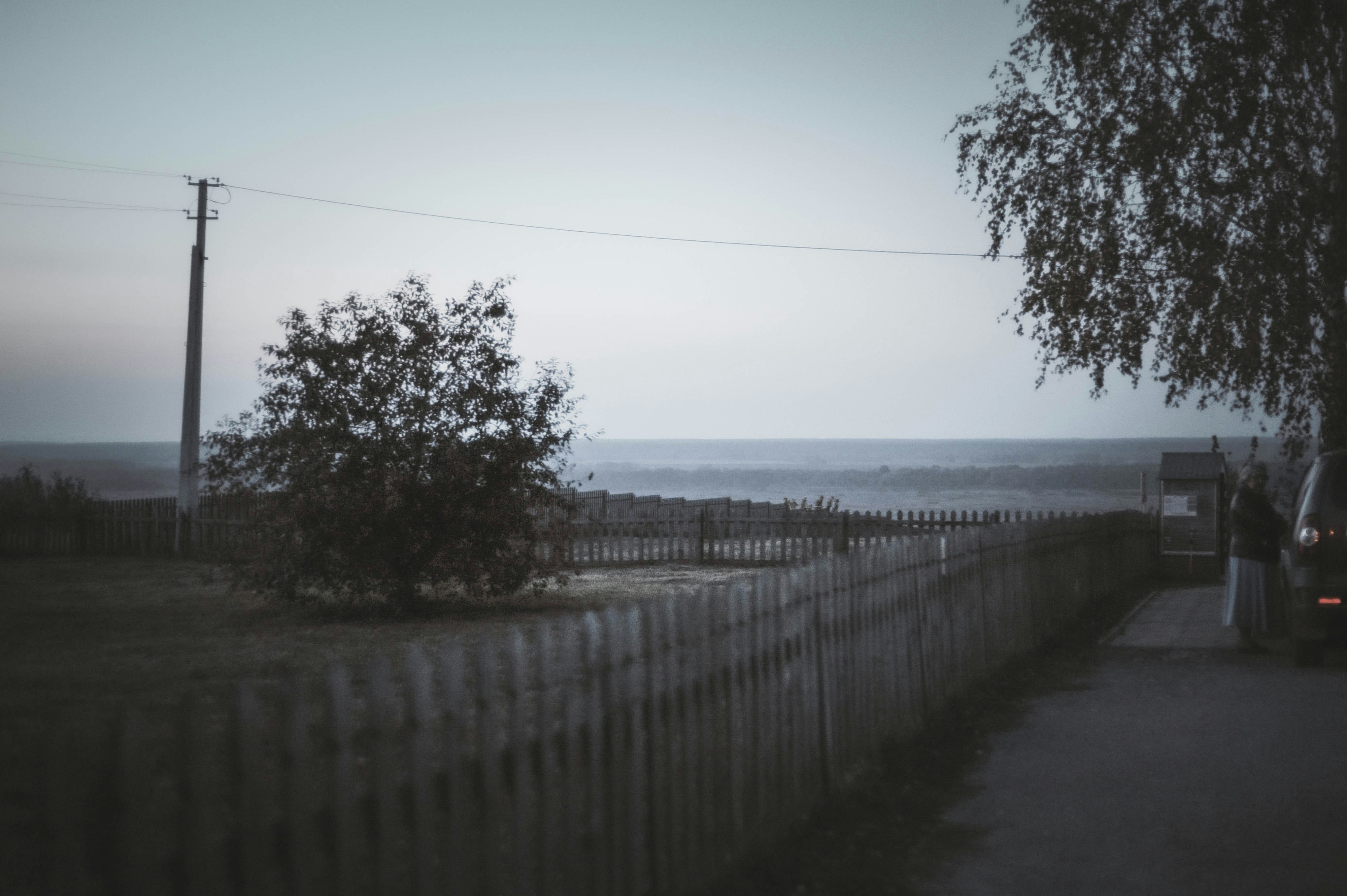 Sea Gate at Dusk: Faded Roadside Calm by the Fence
