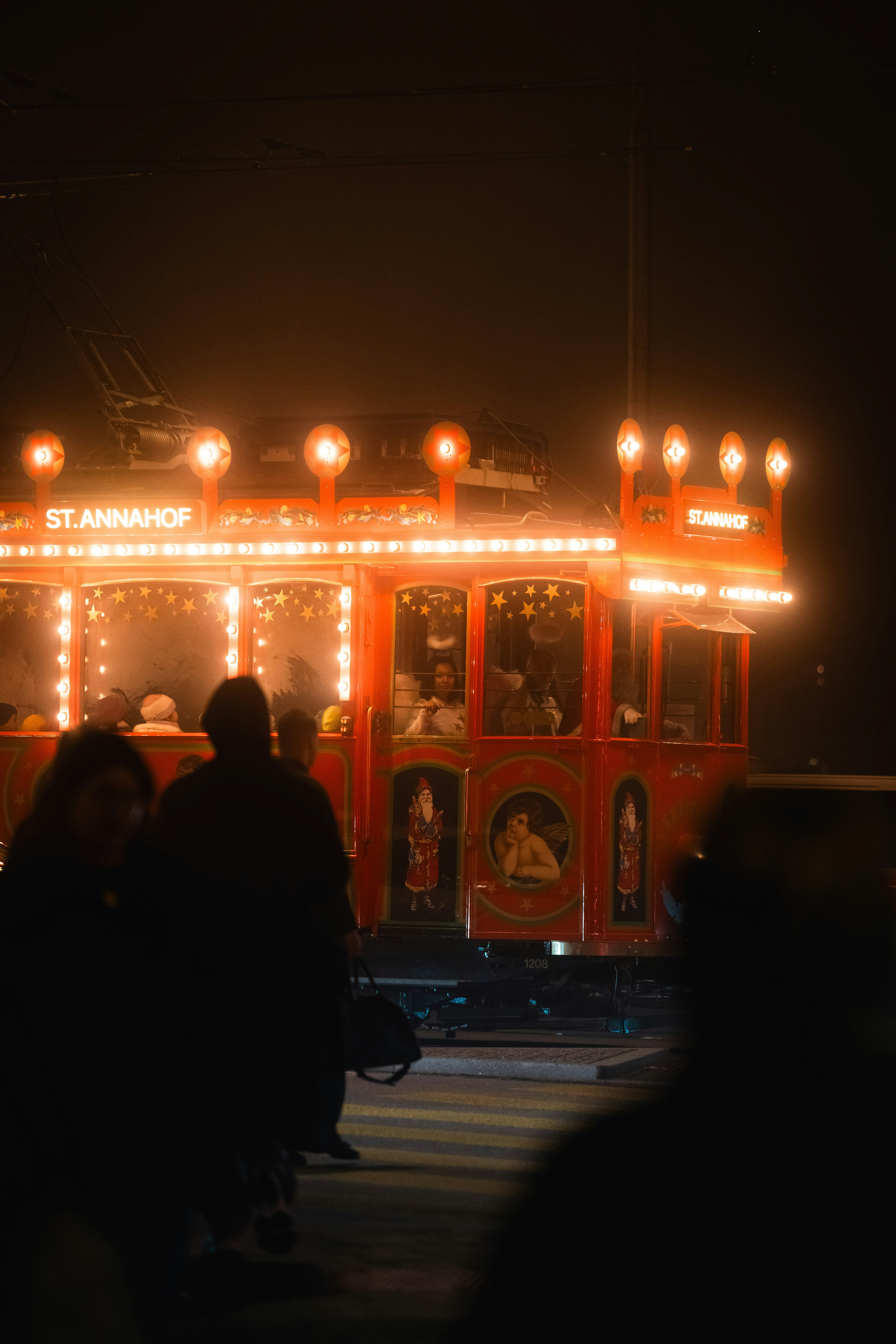 Neon Carousel: A Red Streetcar at Dusk with Silhouetted Passengers