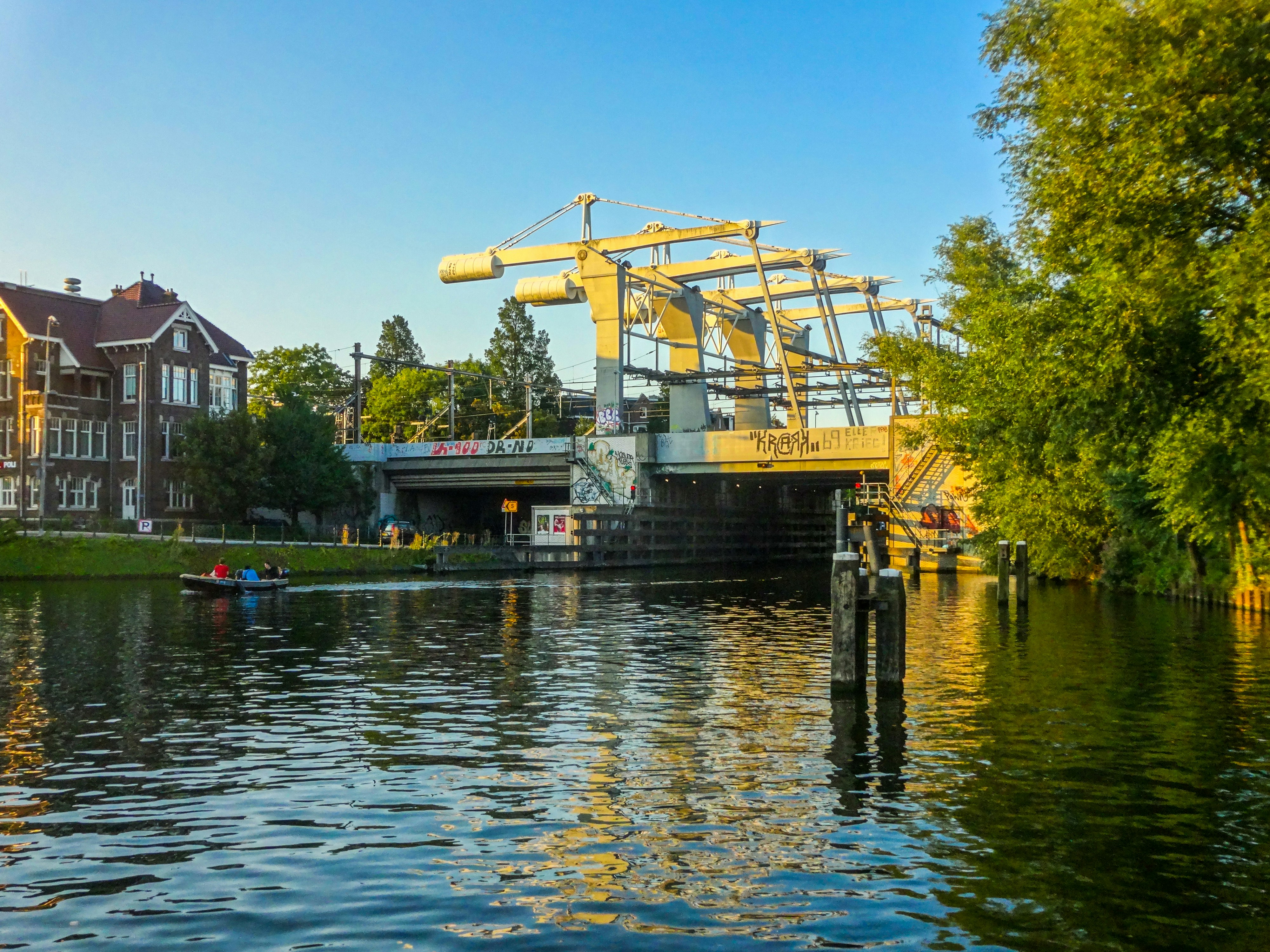 Bridge under construction over a calm canal at golden hour