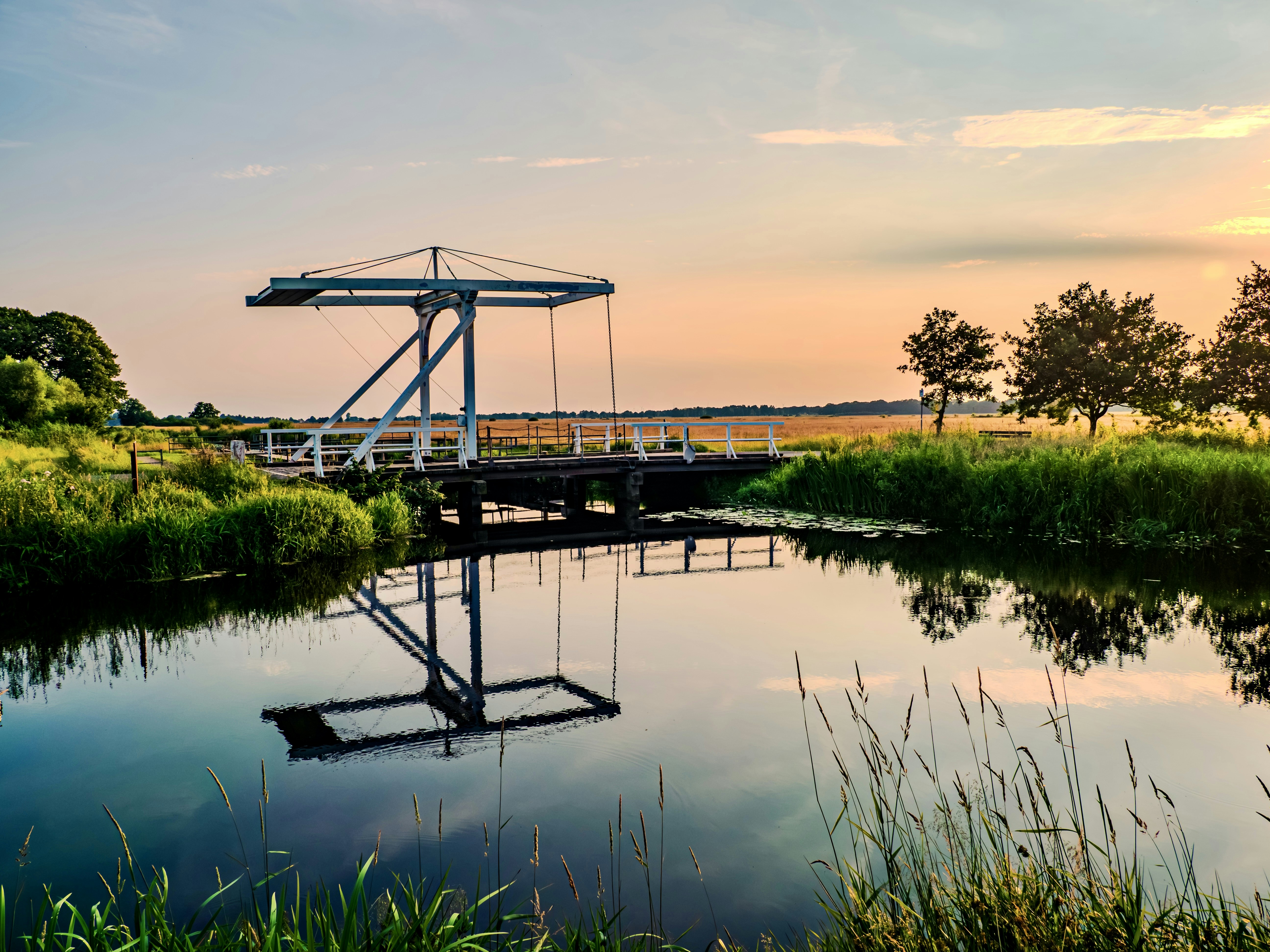 Bridge and reflection at dusk over tranquil canal