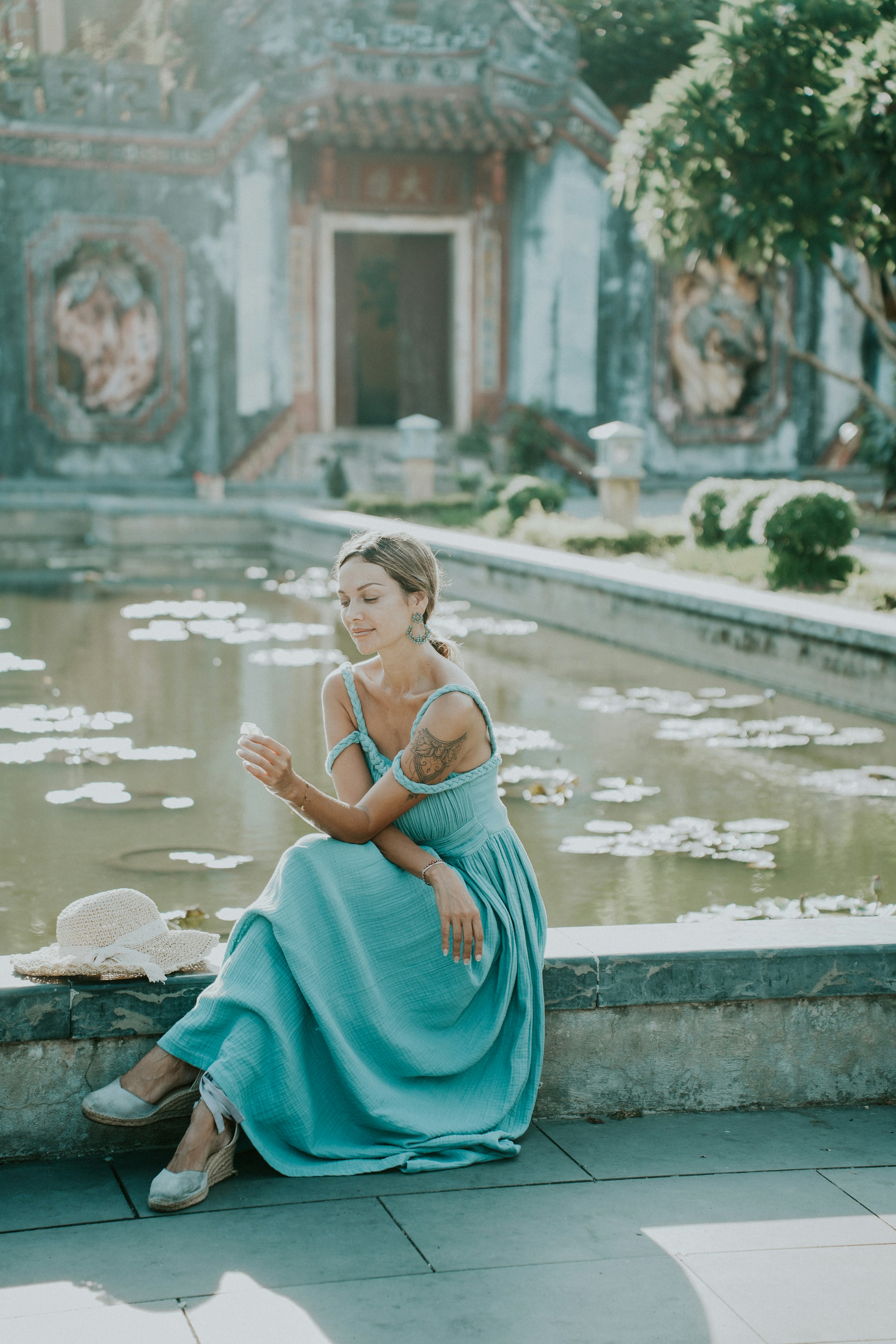 Blue Dress by the Fountain: Quiet Contemplation in a Teal- tiled Garden