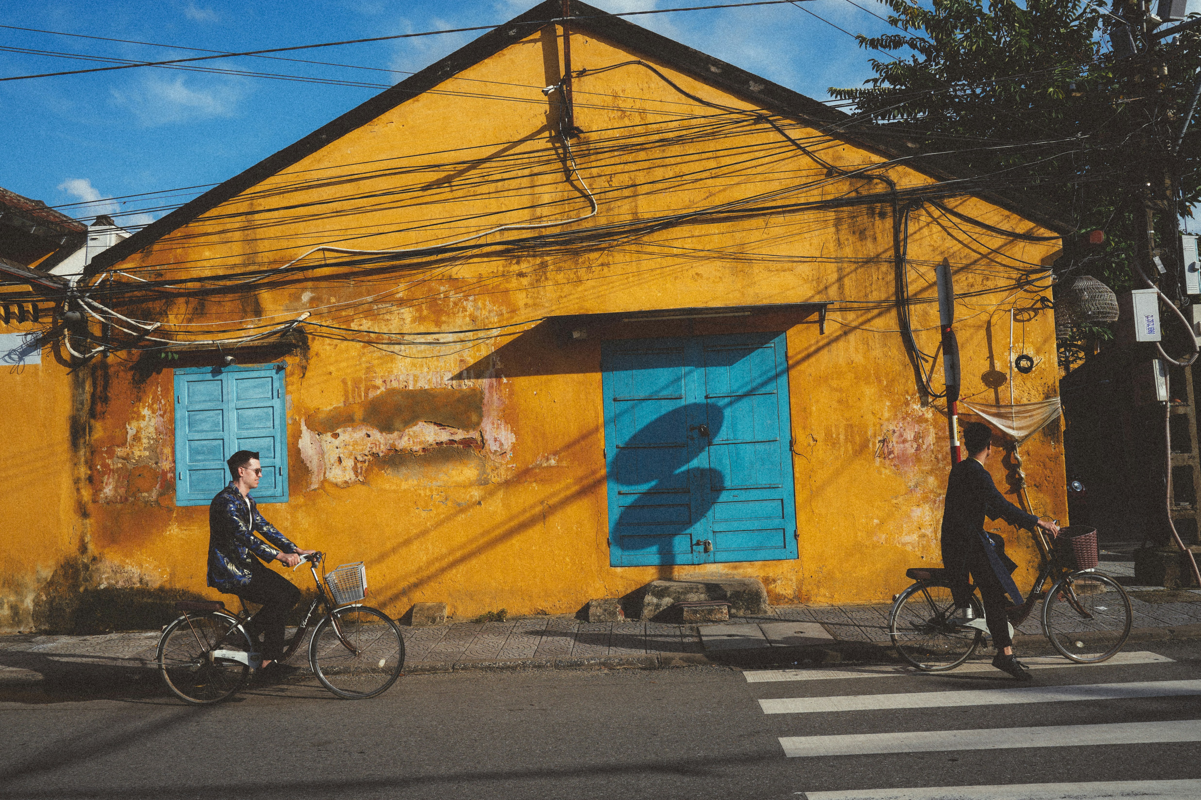 Yellow facade and moving silhouettes on a sunny street