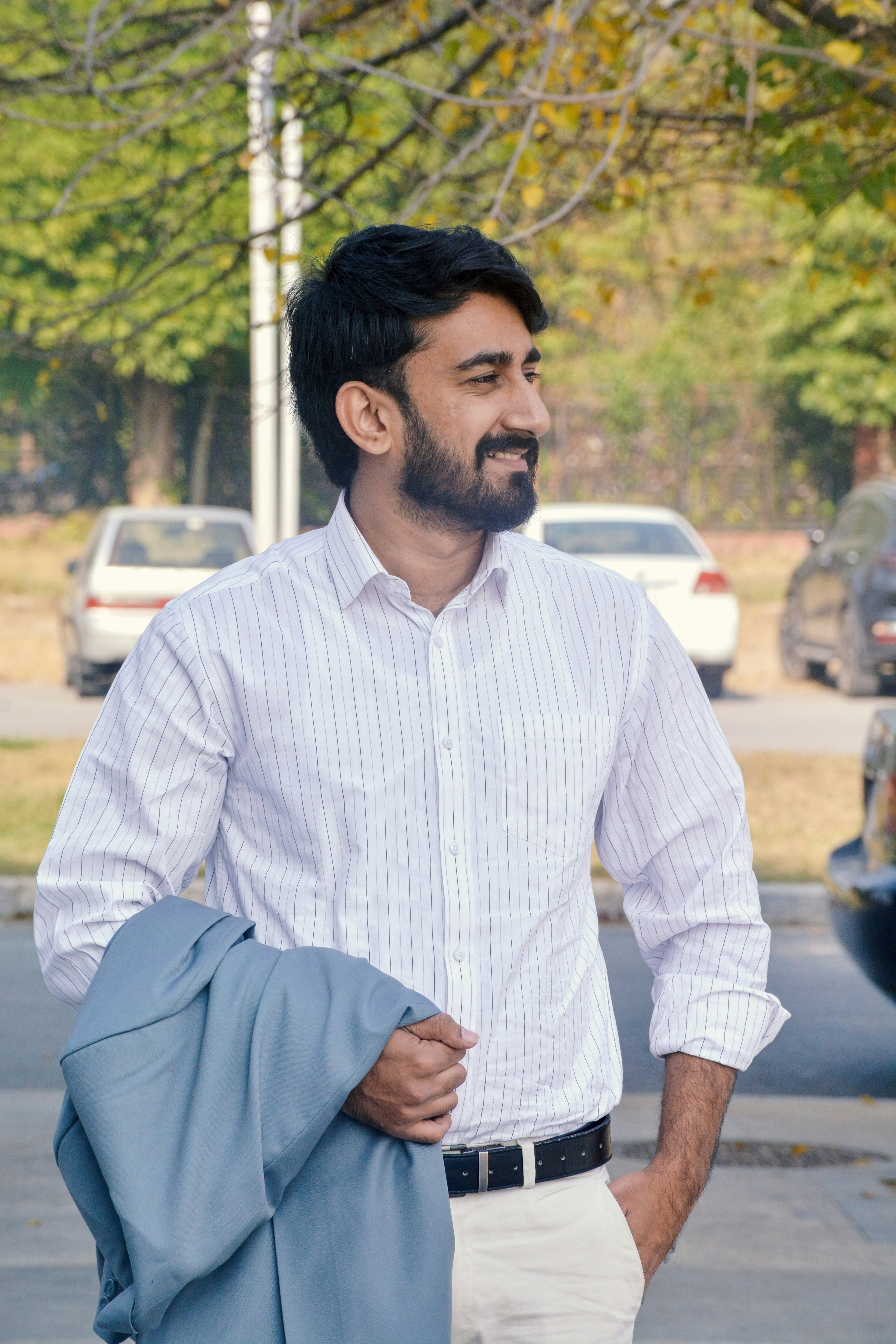 A Sunlit Portrait of Confidence: The Smiling Man in a Striped Shirt