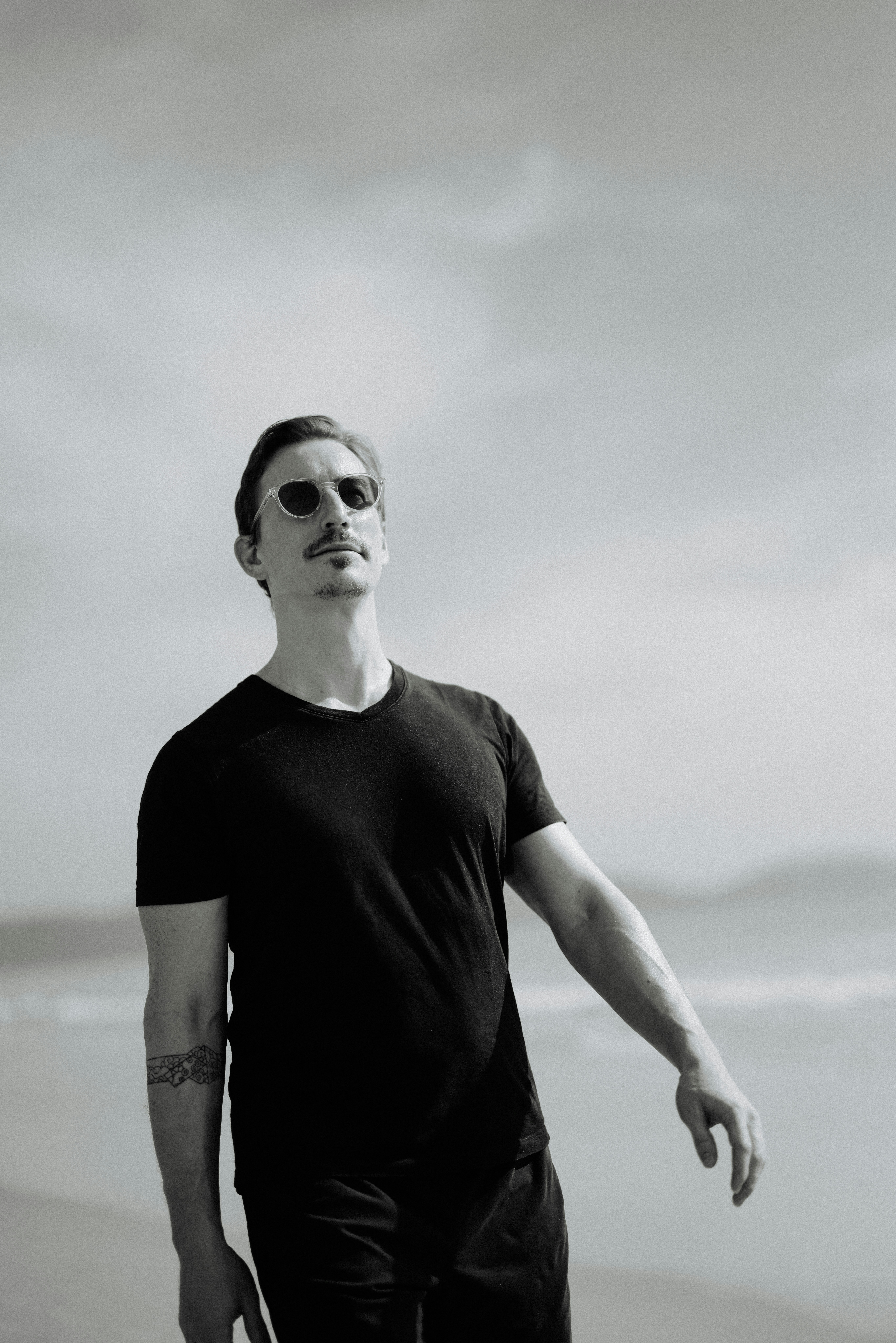 Portrait on the Shore: A Sunlit Stance in Mono