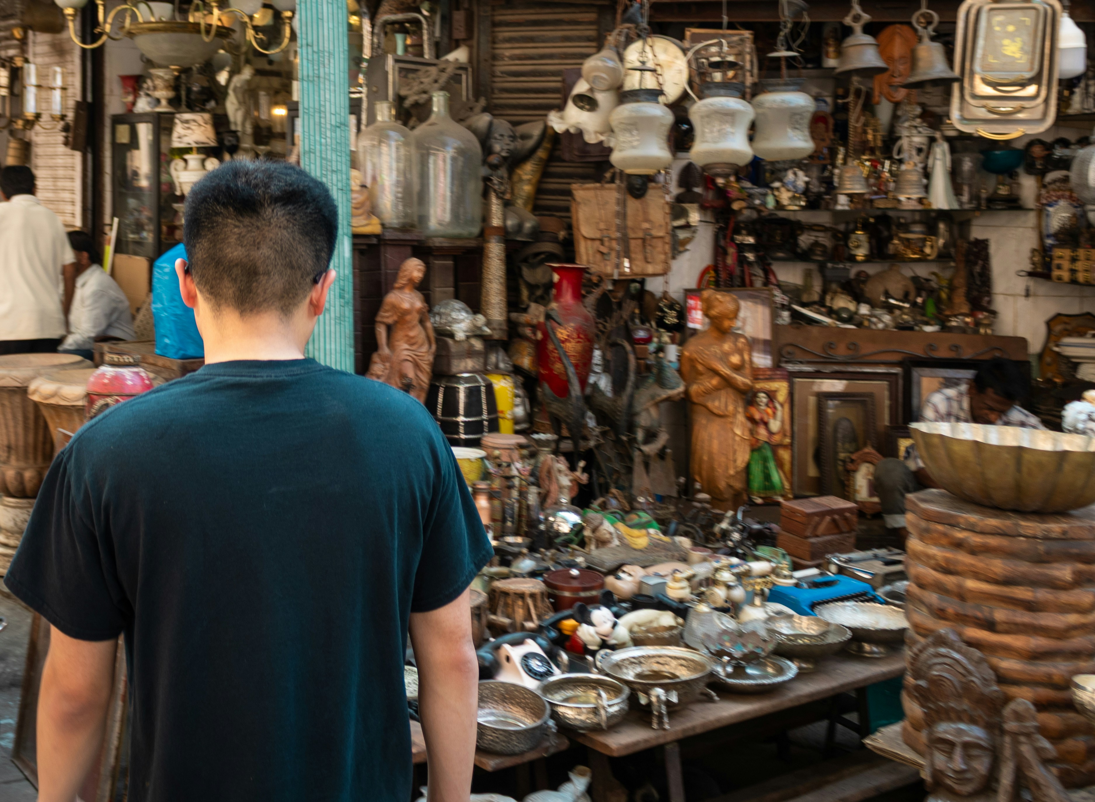 Market Portrait: The Back of a Curious Visitor Amid Vintage Trinkets