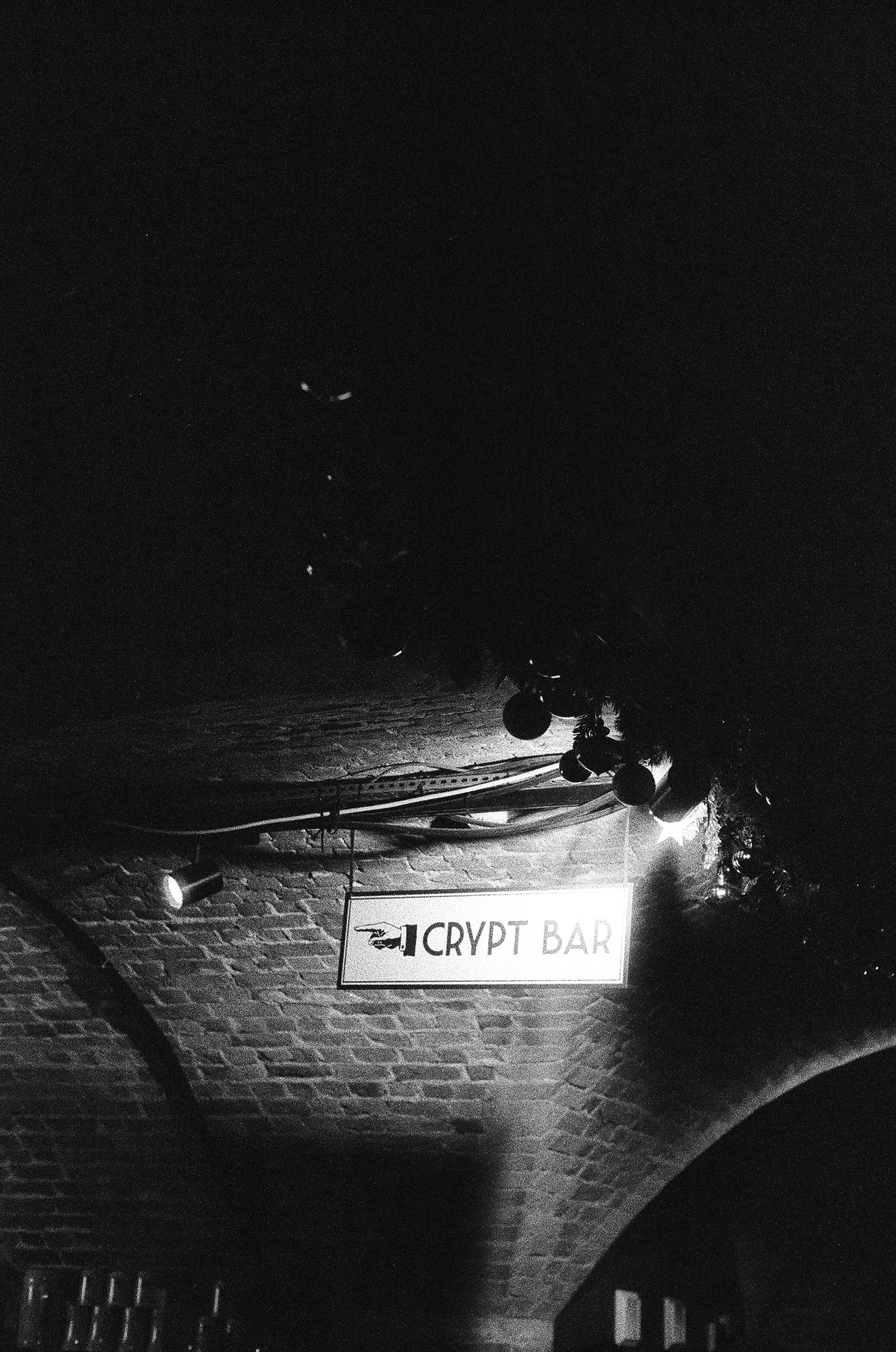 Sign for crypt bar illuminated in dark brick archway photo – Free Brick ...