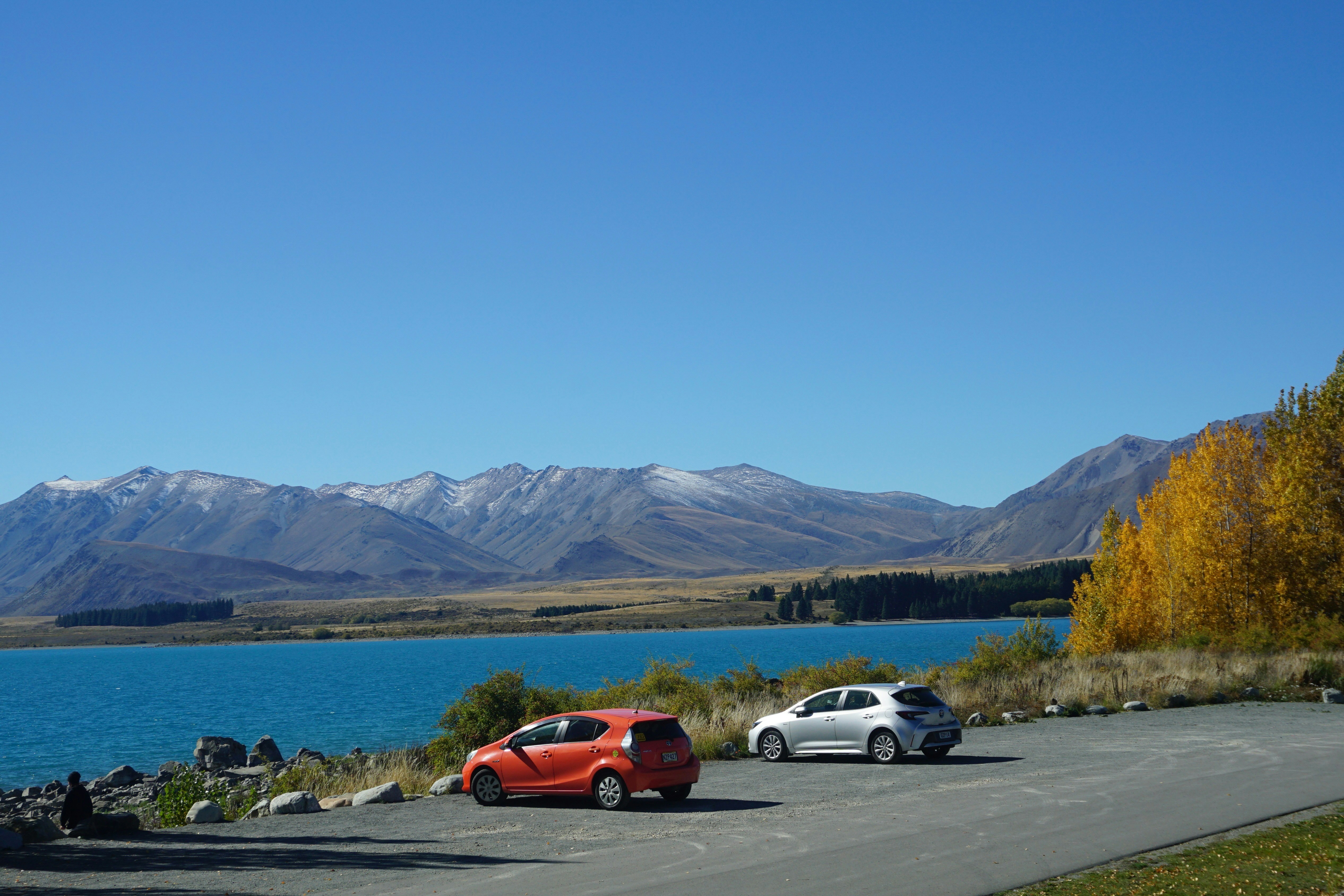 Orange Hatchback at the Lakefront Under Alpine Vista