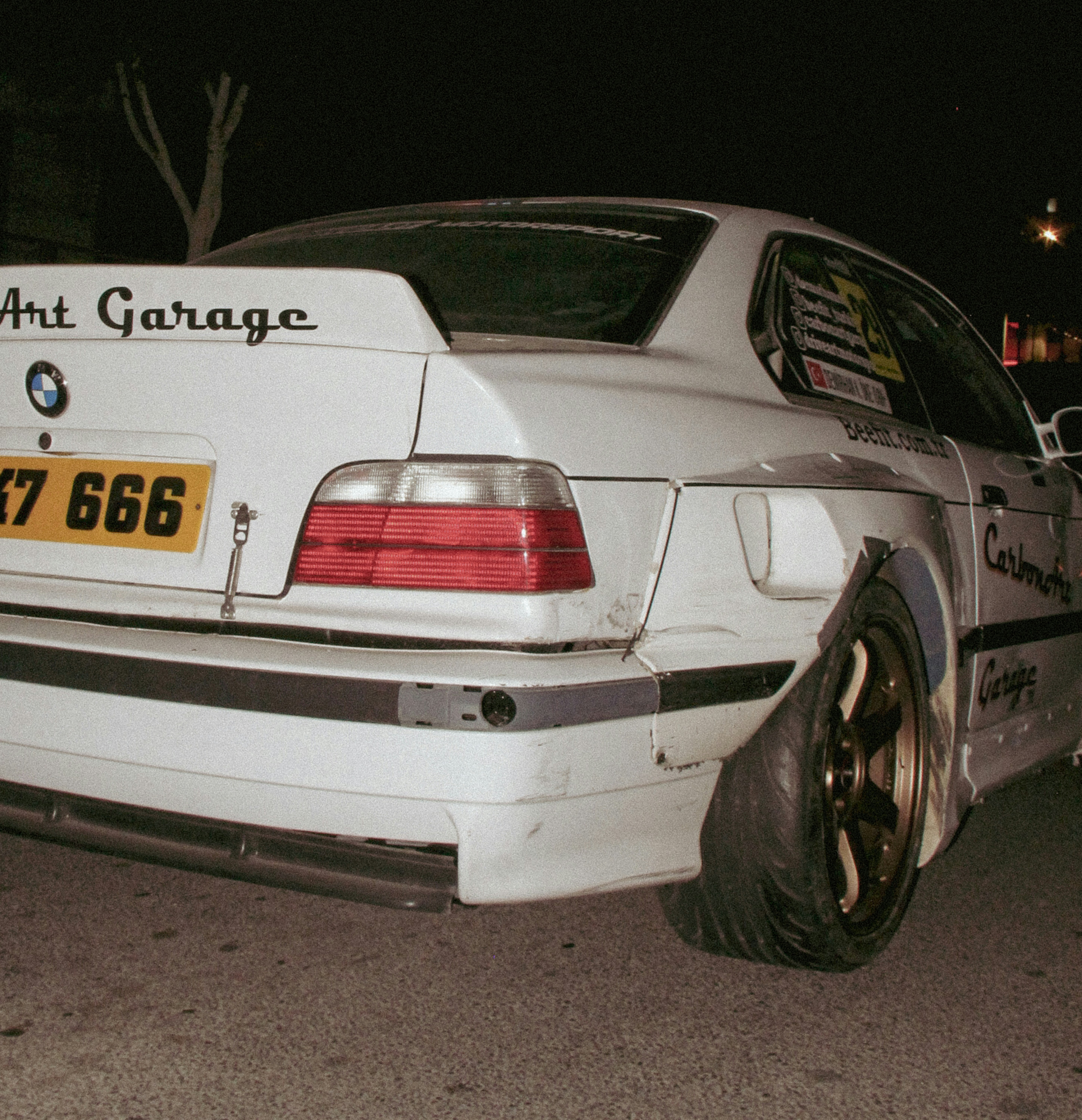 Rear-Quarter of a Dented Drift Car under Night Streetlights