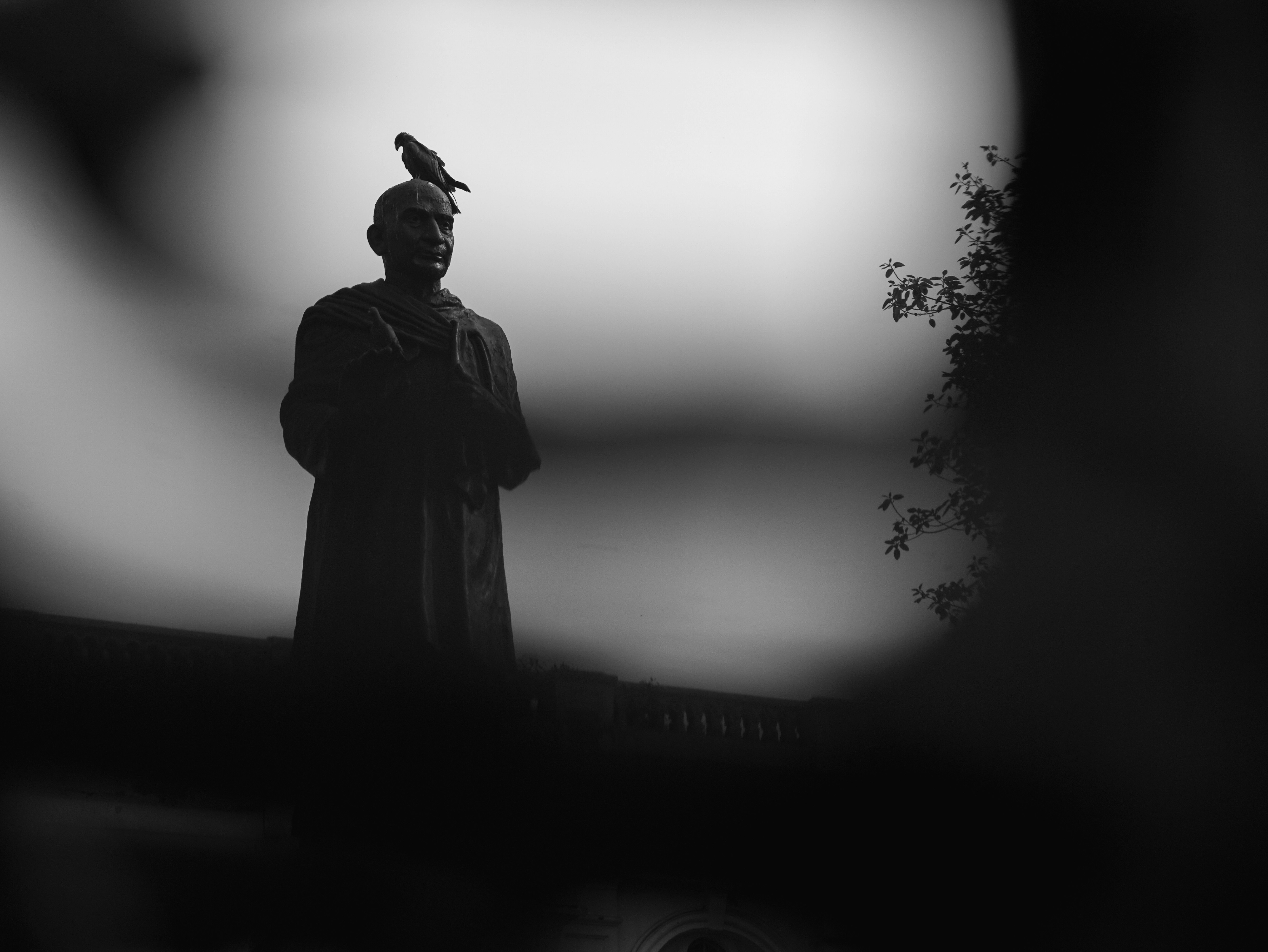 Statue in silhouette beneath a hazy halo